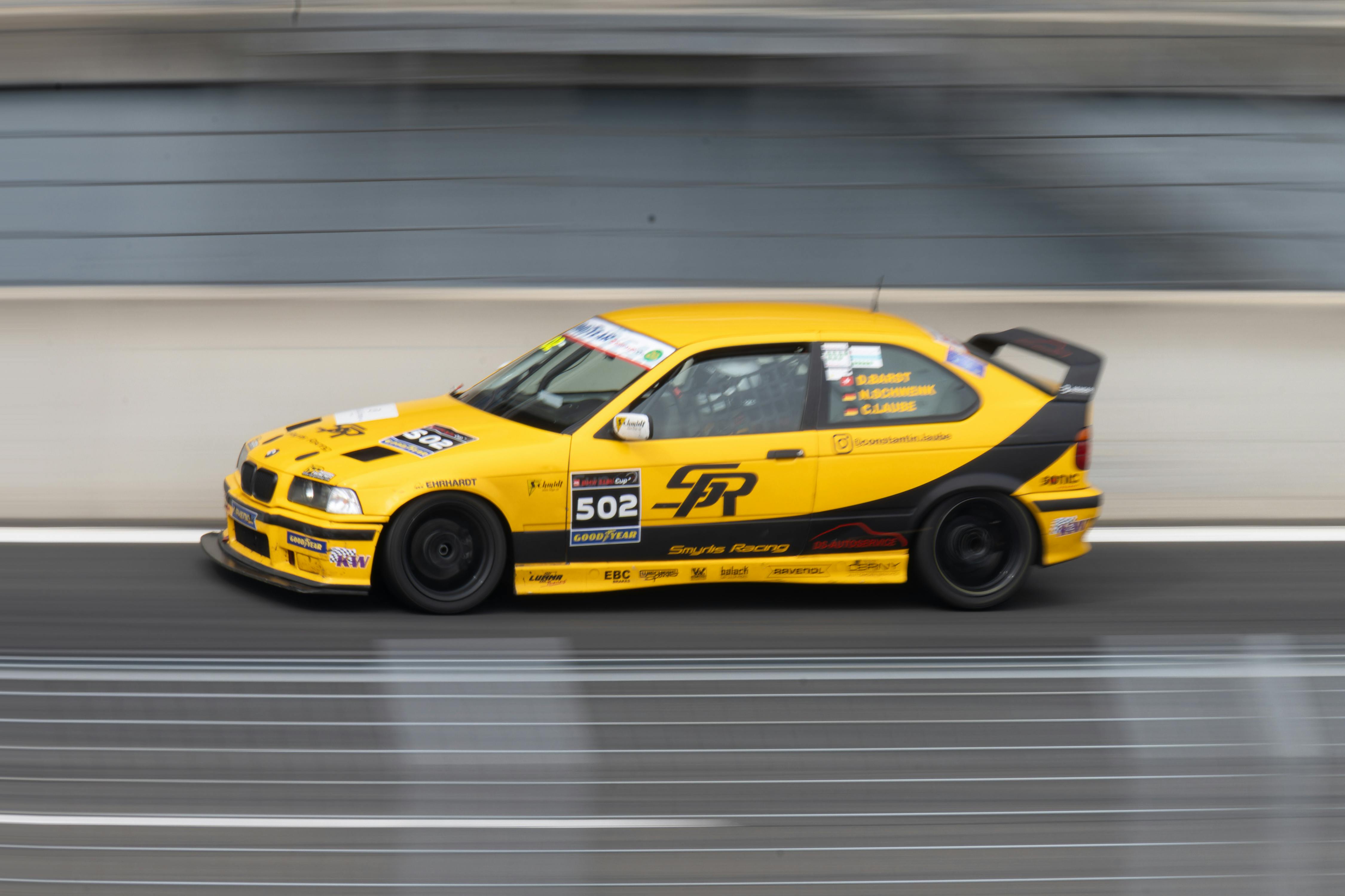 High-Speed Yellow Racing Car on Track · Free Stock Photo
