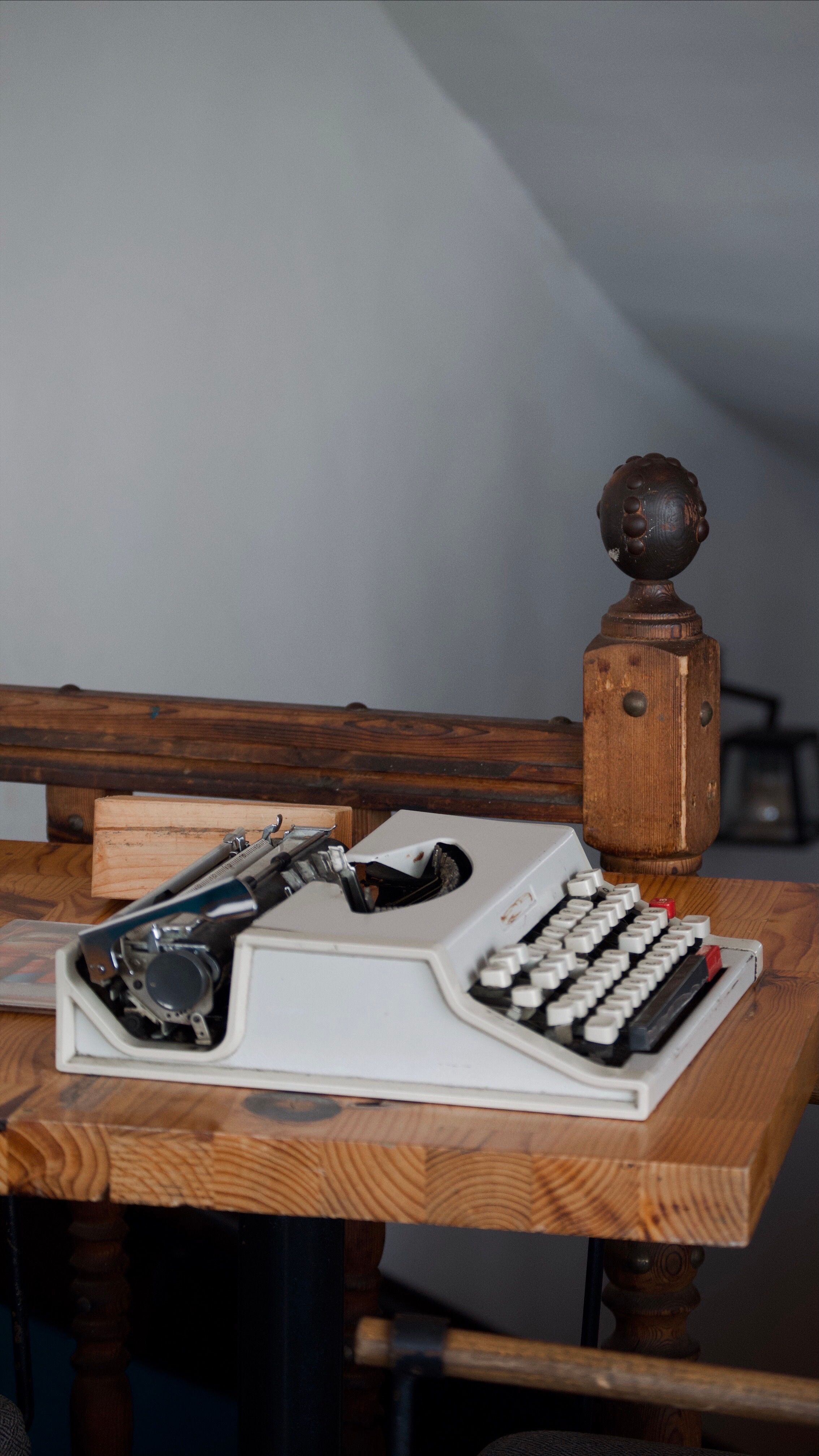 A typewriter sits on a wooden table · Free Stock Photo