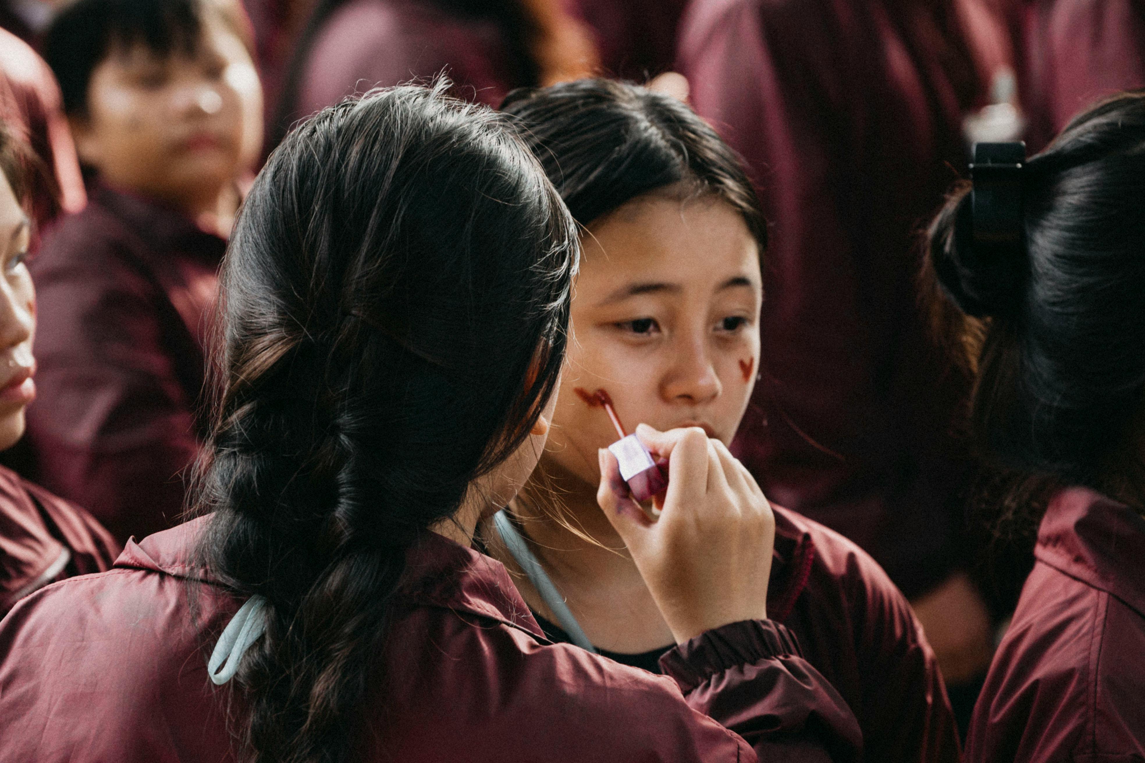 Teenagers Applying Face Paint at Outdoor Event · Free Stock Photo