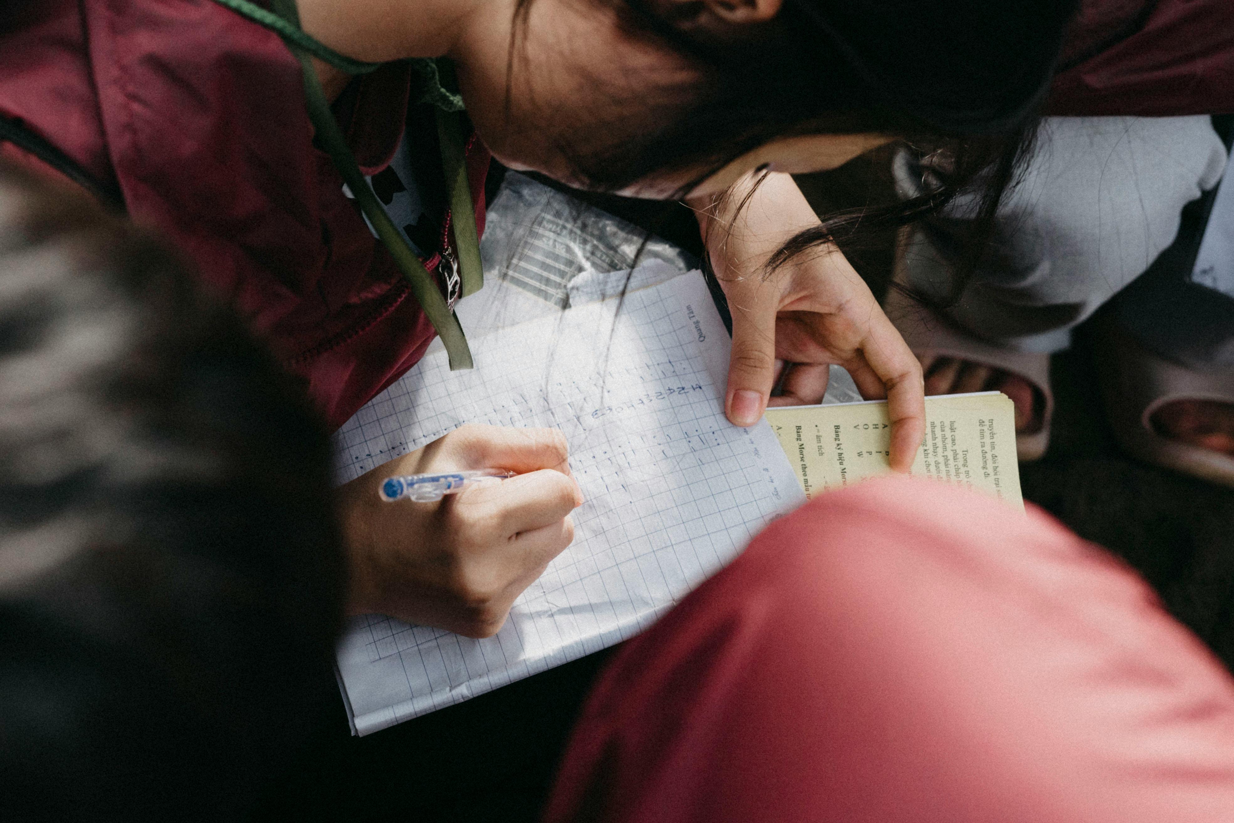 Student Writing in Notebook During Outdoor Class · Free Stock Photo