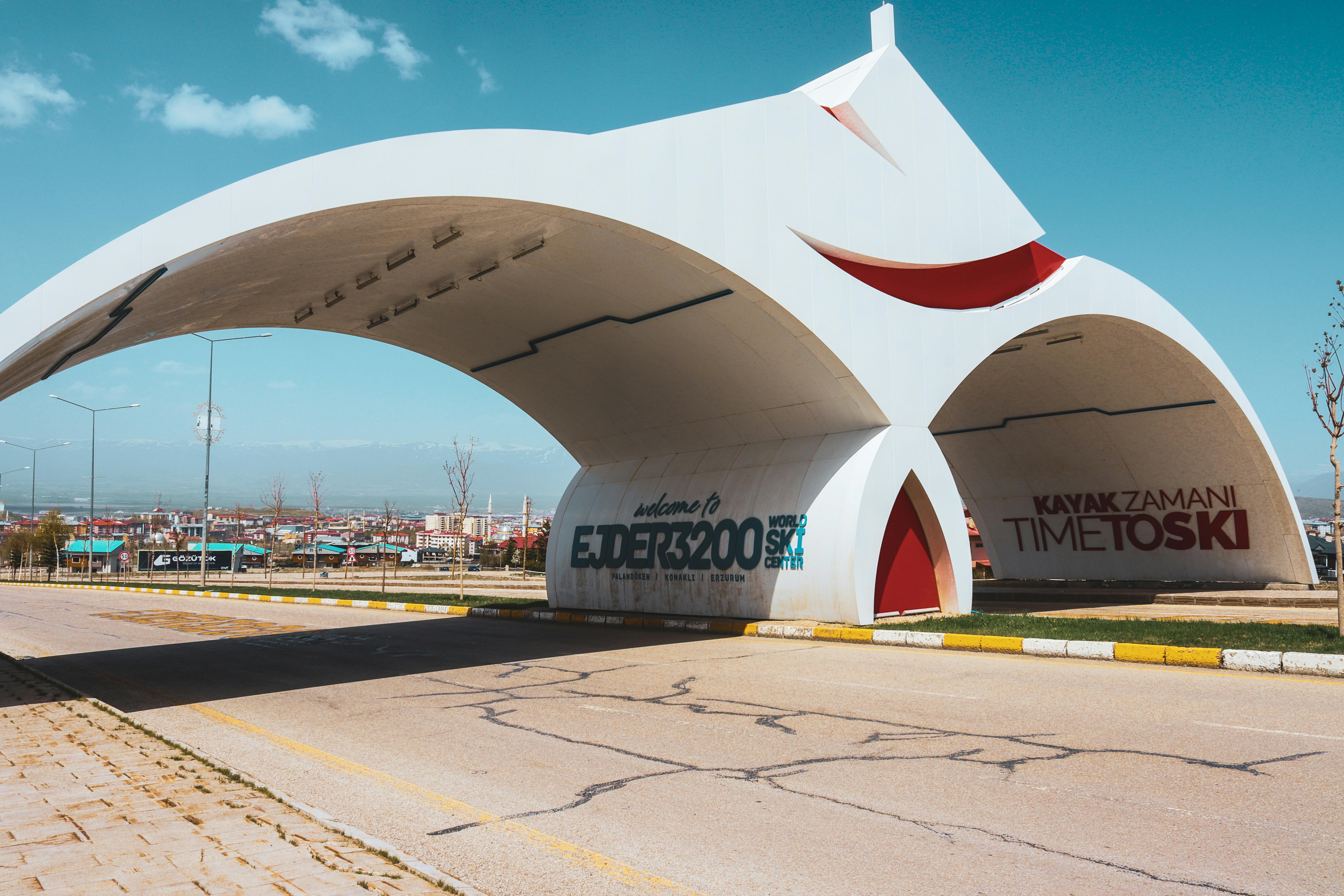 A white arch with red and white writing on it · Free Stock Photo
