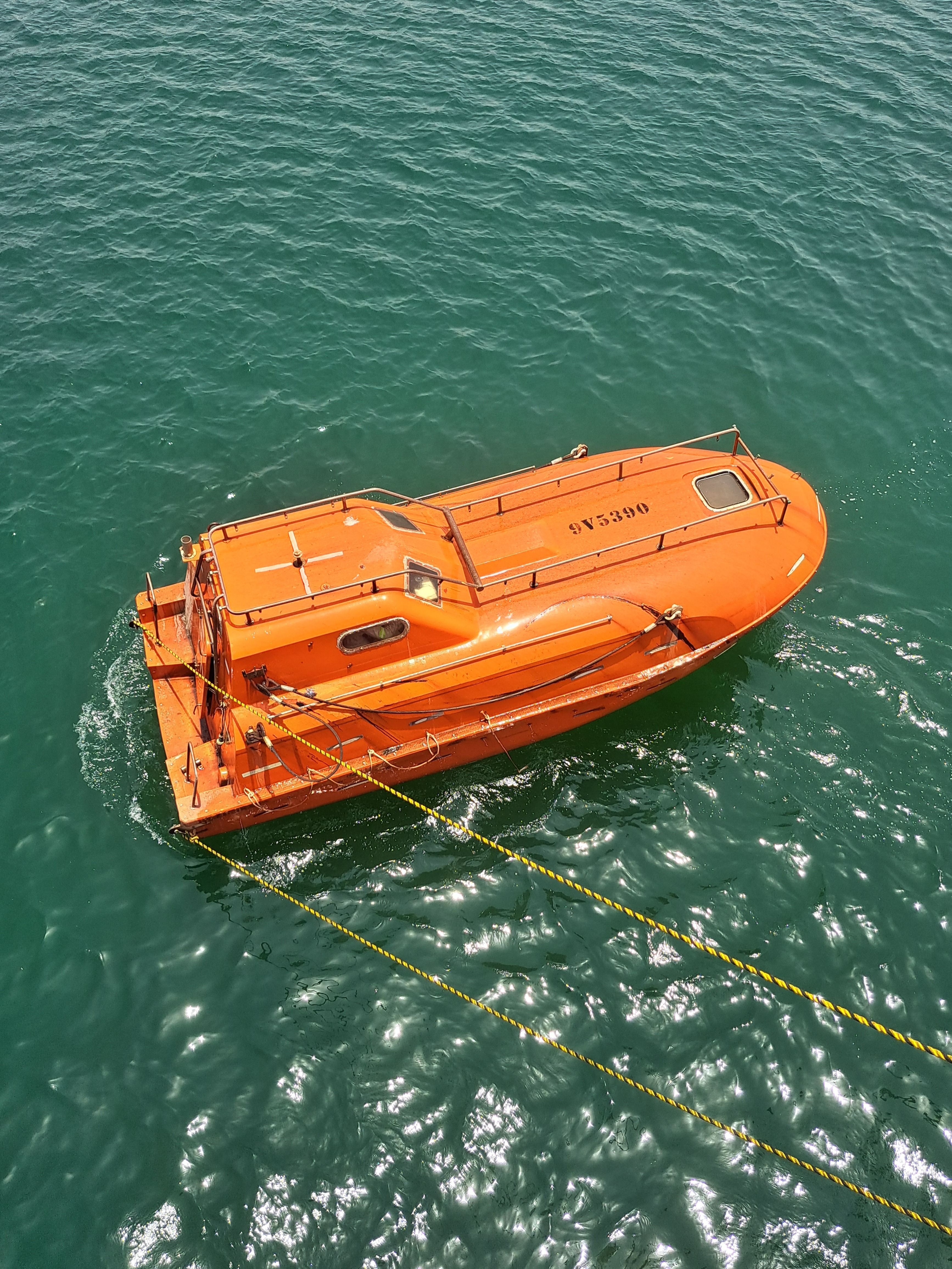 An orange boat floating in the water · Free Stock Photo