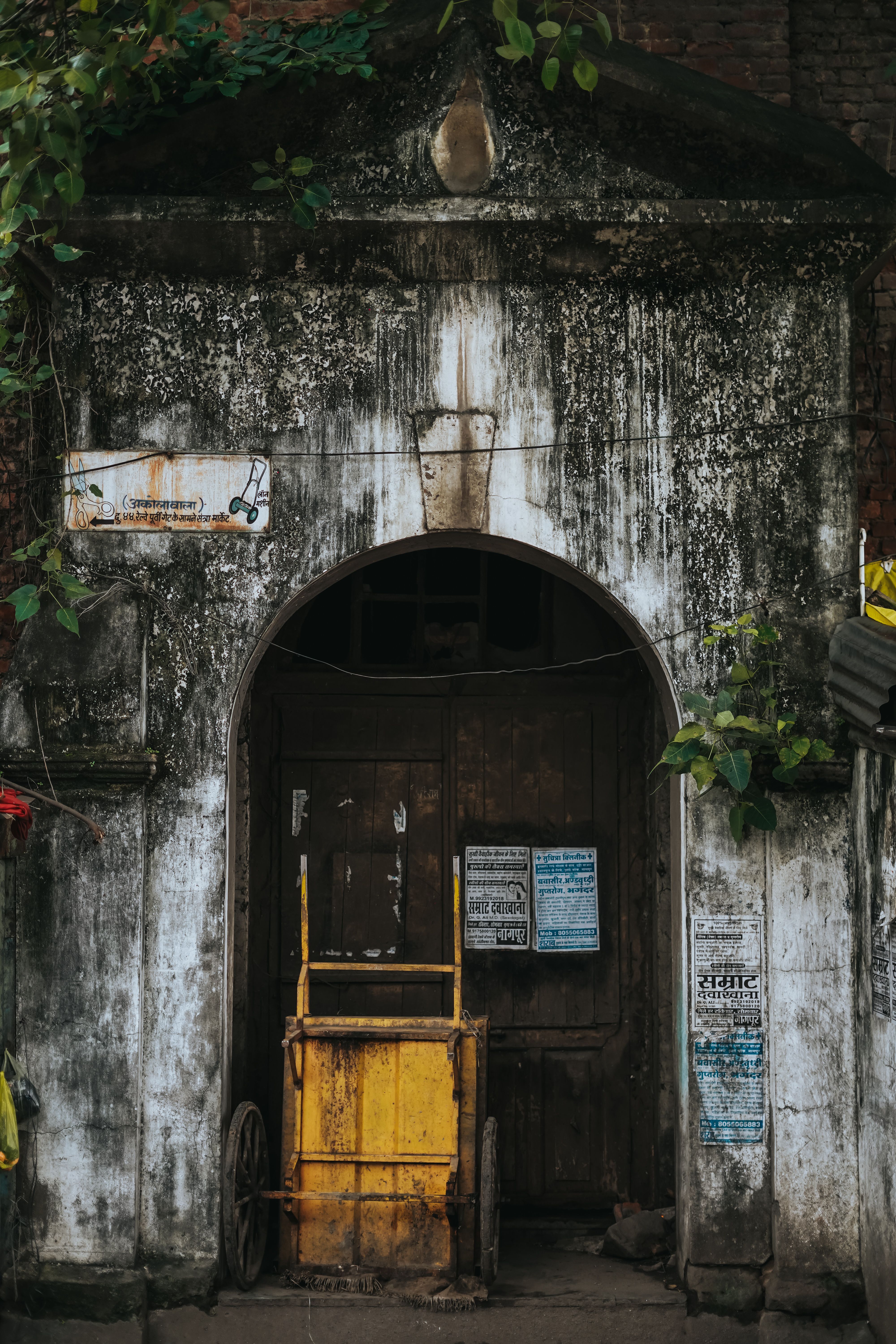 A yellow cart sits in front of an old building · Free Stock Photo