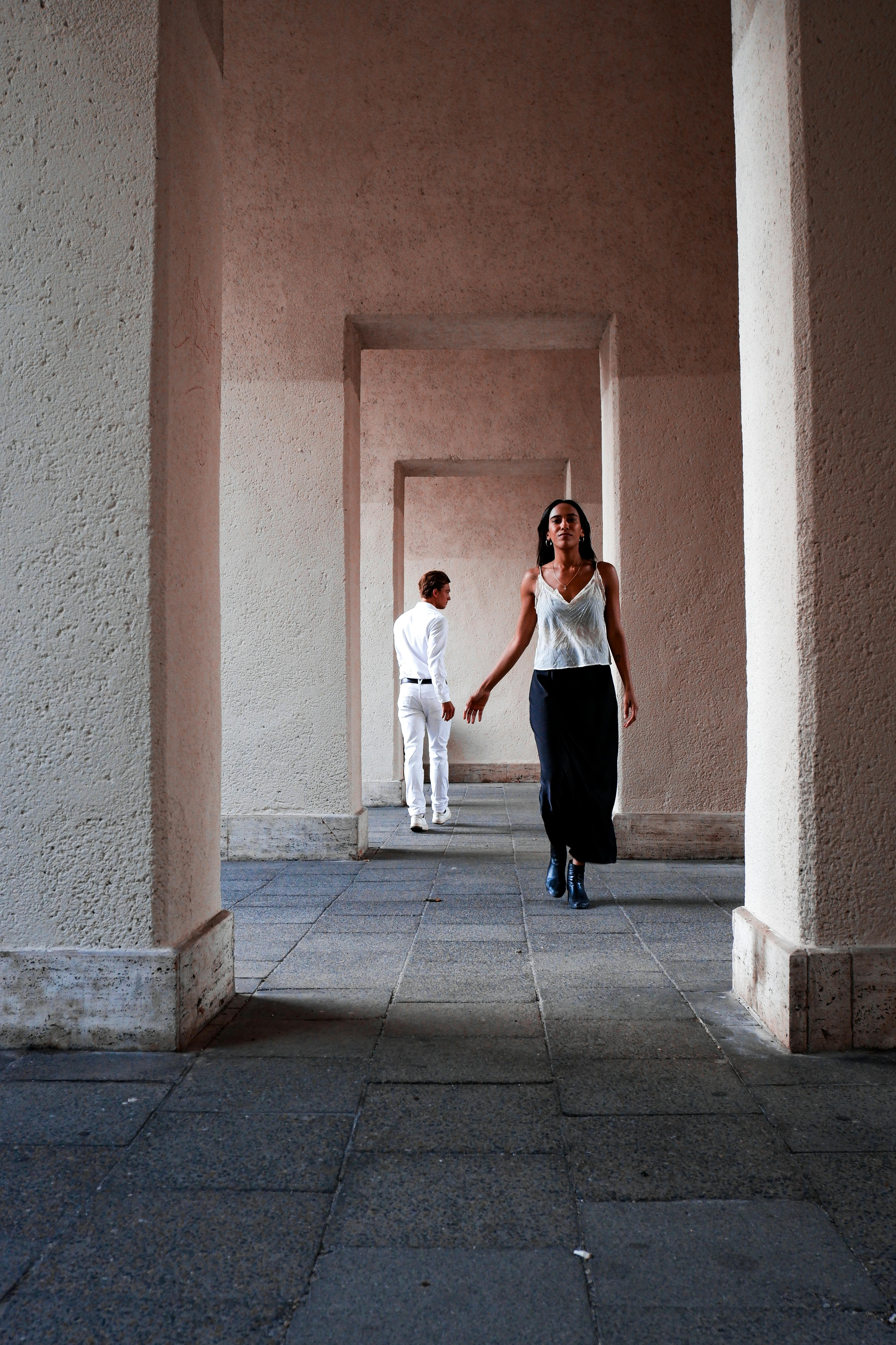 Woman and Man Walking between Walls · Free Stock Photo