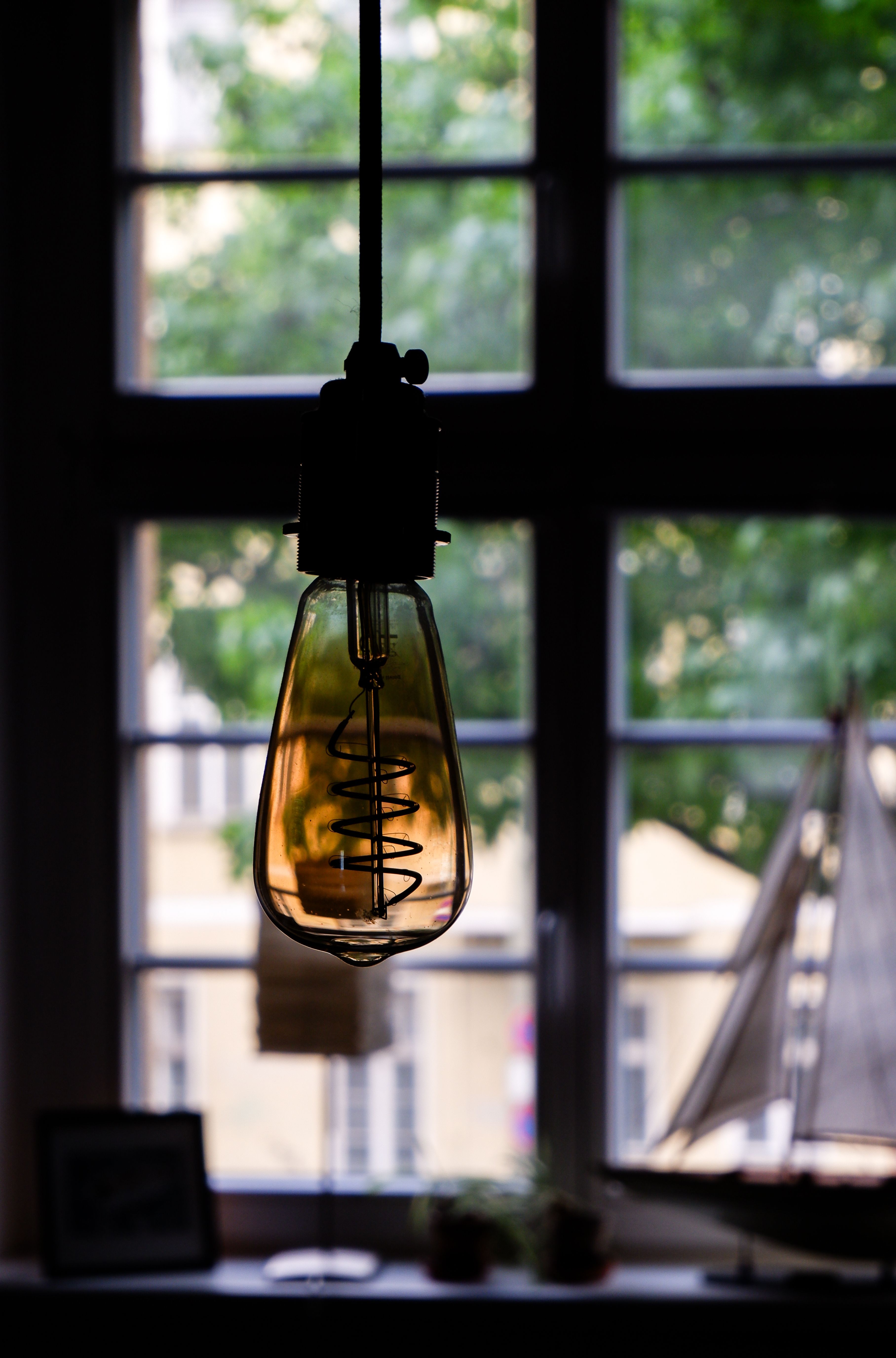 Light Bulb Hanging against a Window · Free Stock Photo