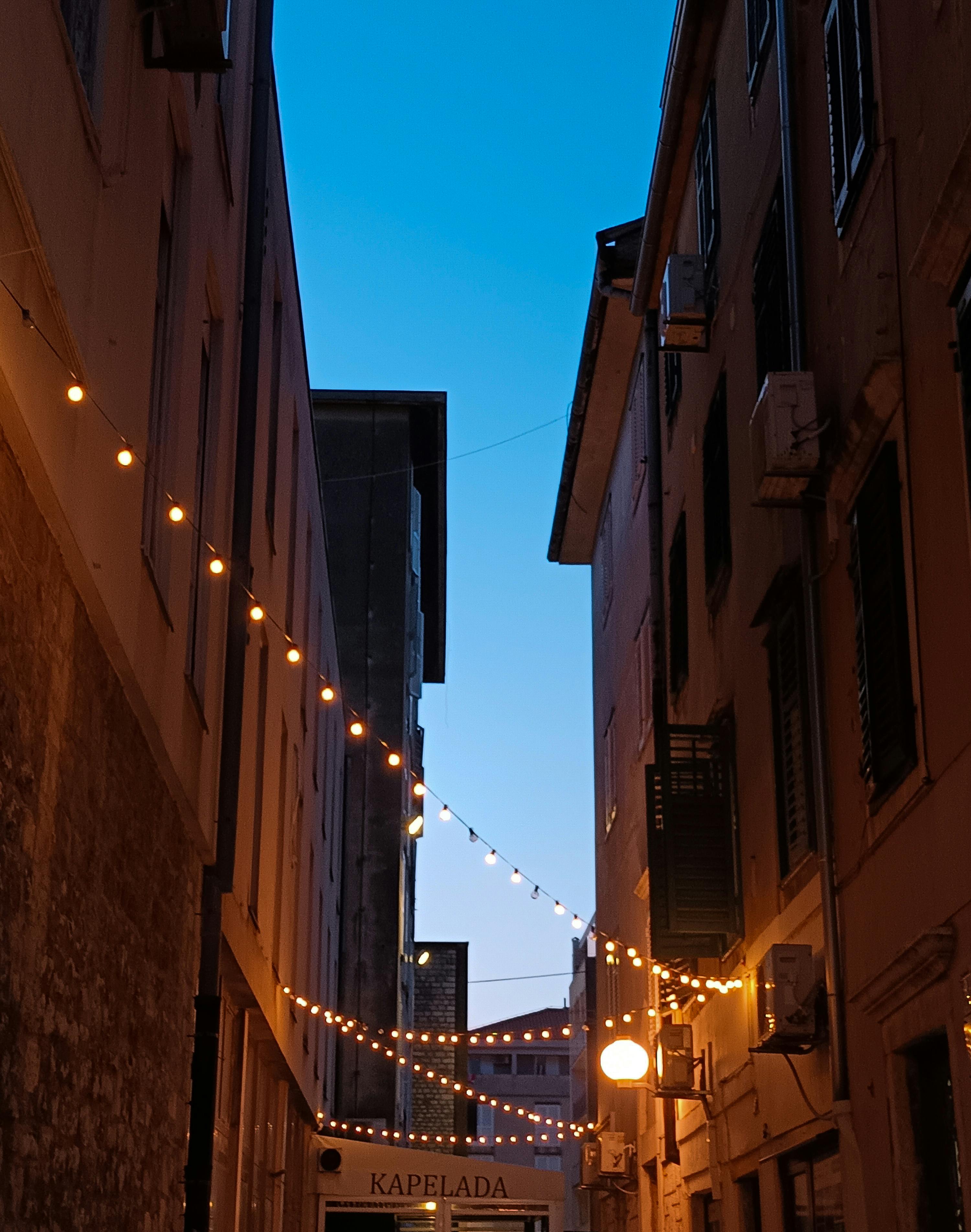 A street with lights strung across it · Free Stock Photo