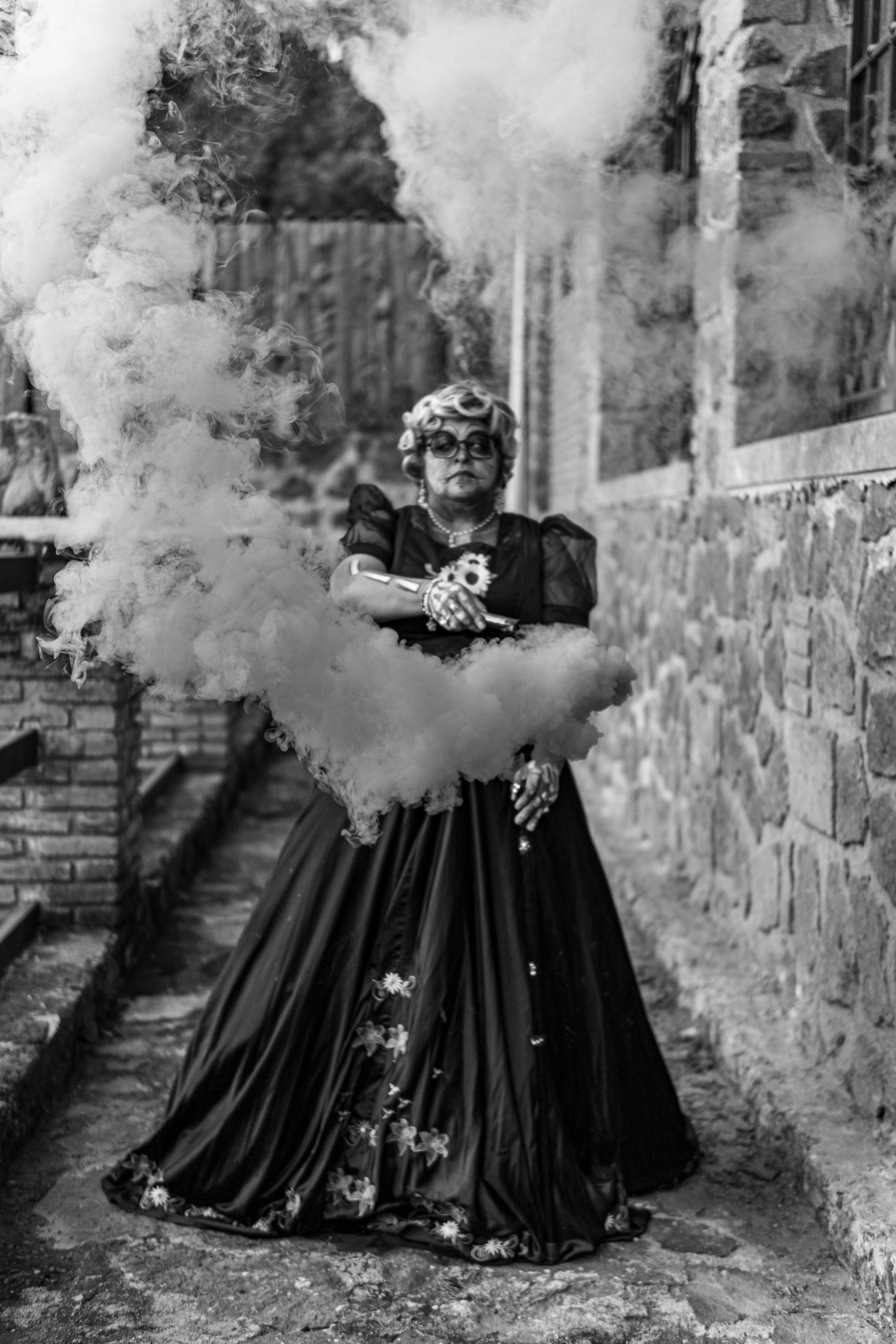 A woman in a black dress and veil smoking · Free Stock Photo