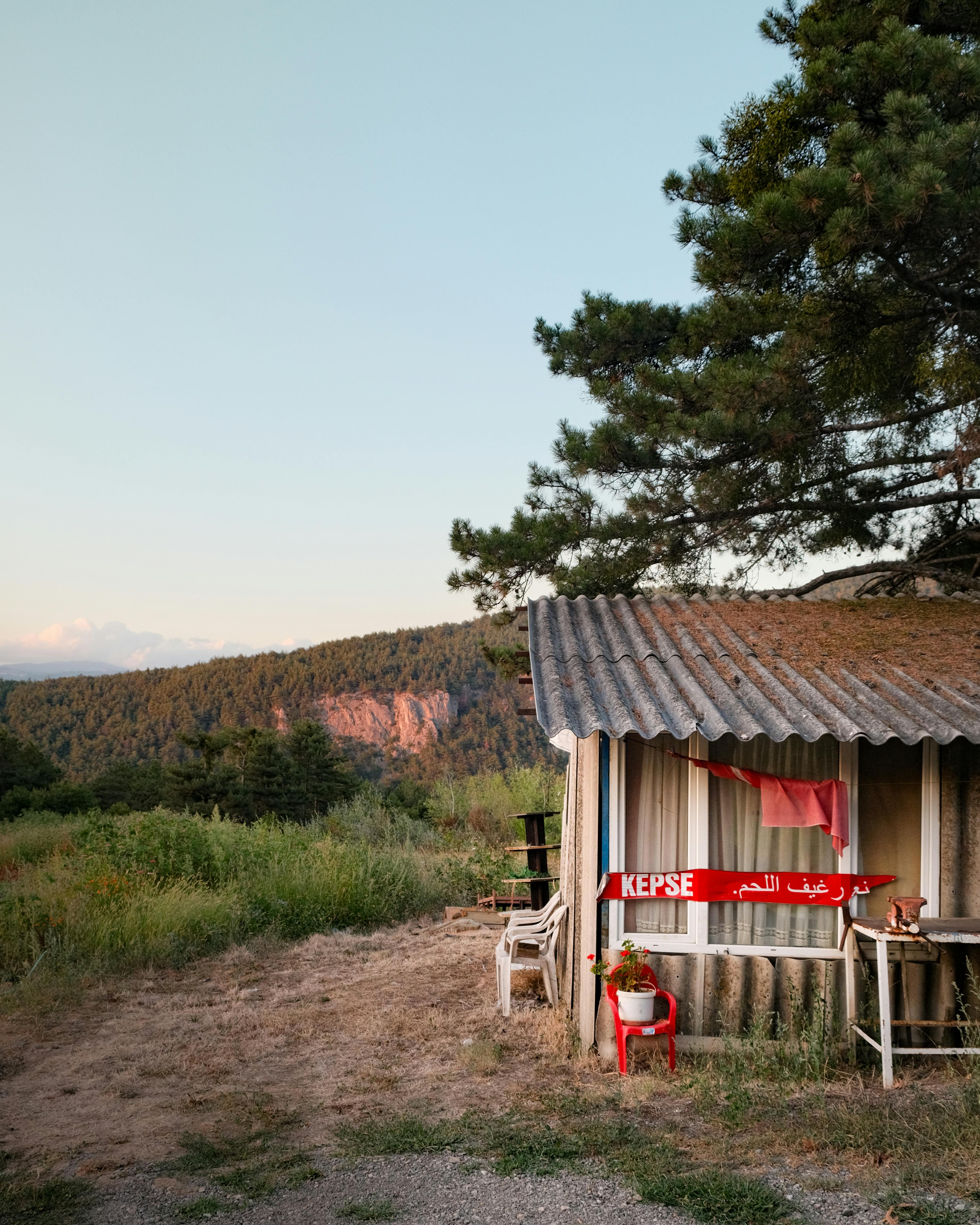 A small shack with a red flag on top of a hill · Free Stock Photo