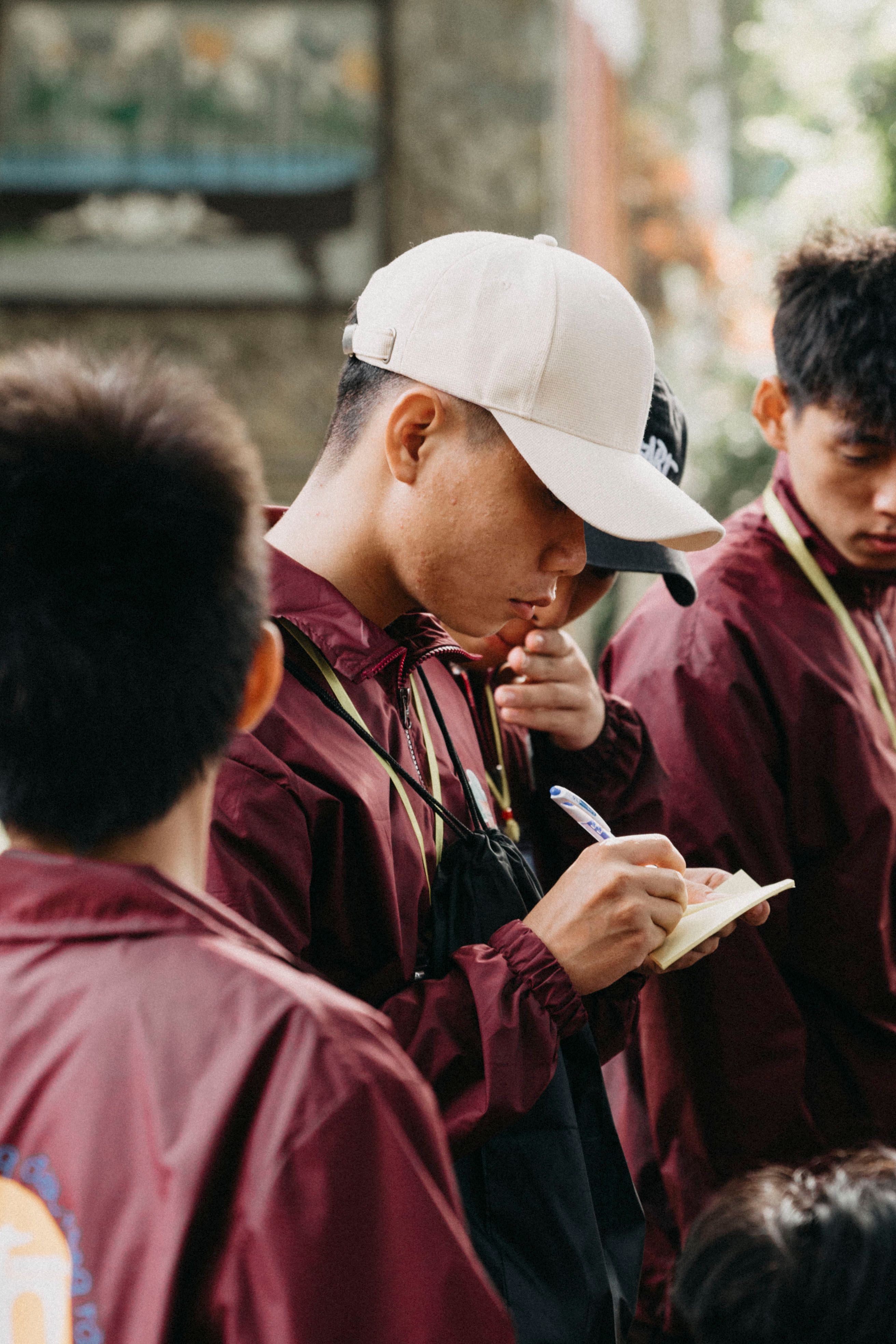 Group of Young Adults in Maroon Jackets · Free Stock Photo