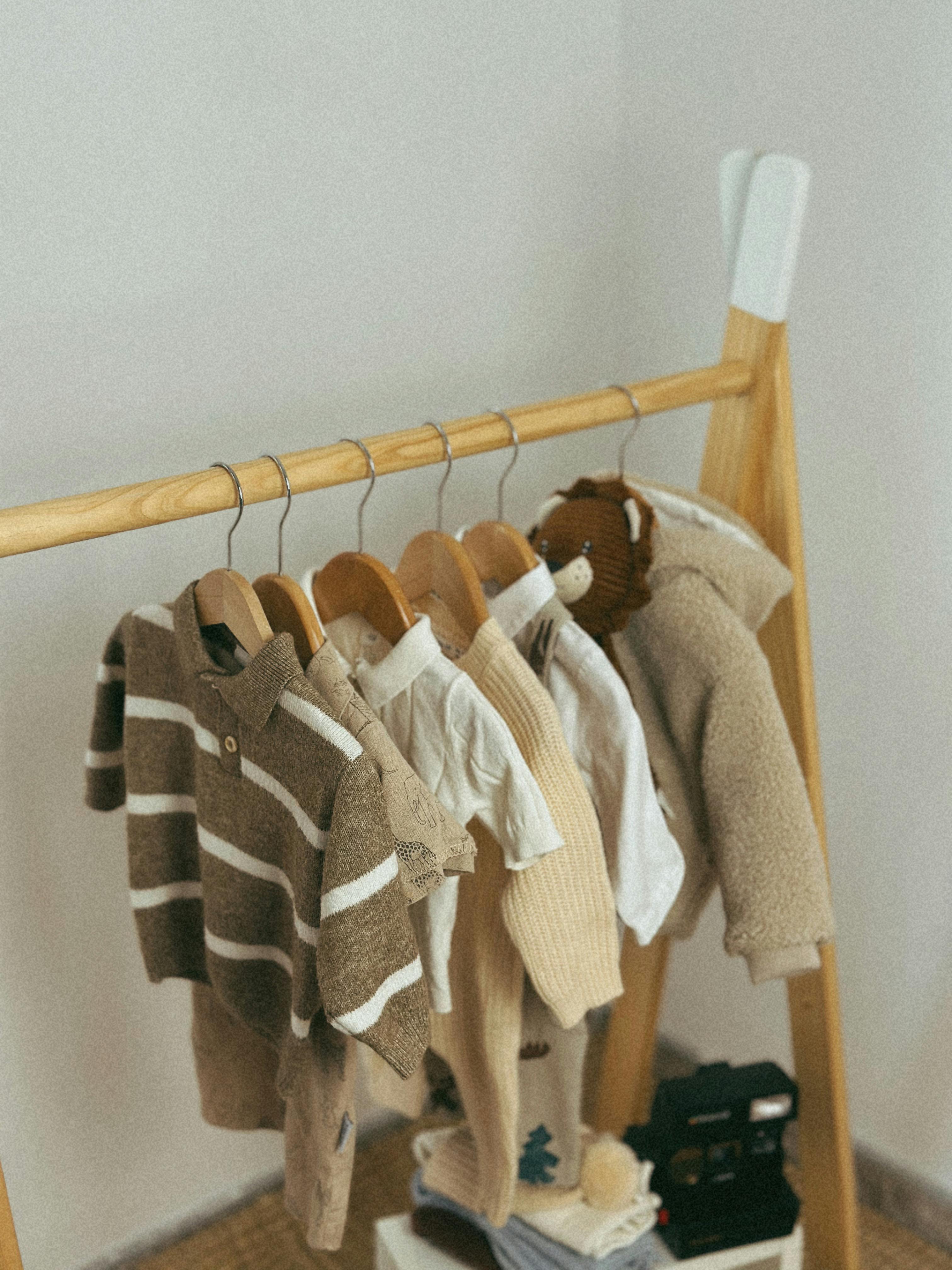 Cozy Baby Clothes on Wooden Rack Display · Free Stock Photo