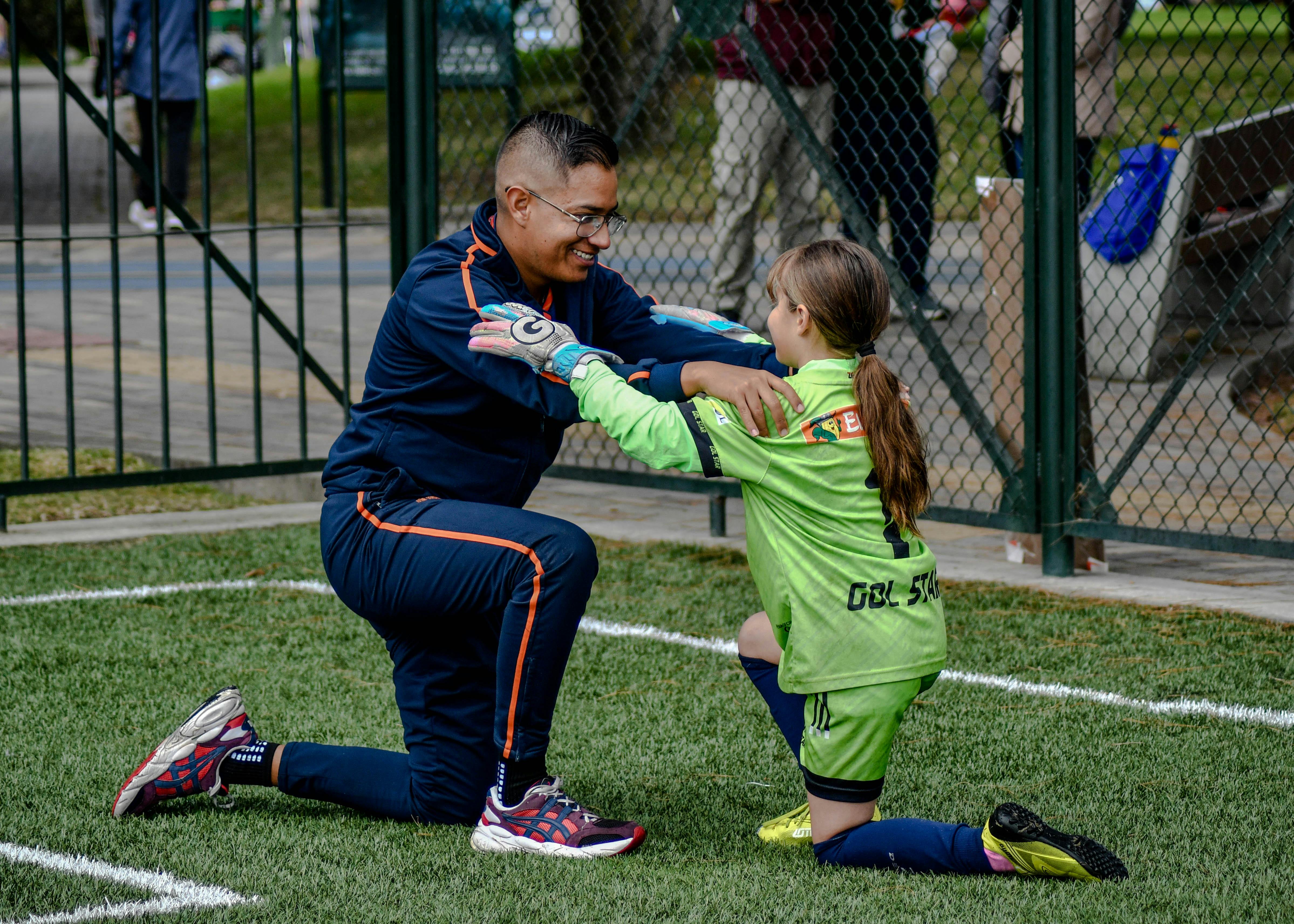 Coach Encouraging Young Soccer Player on Field · Free Stock Photo