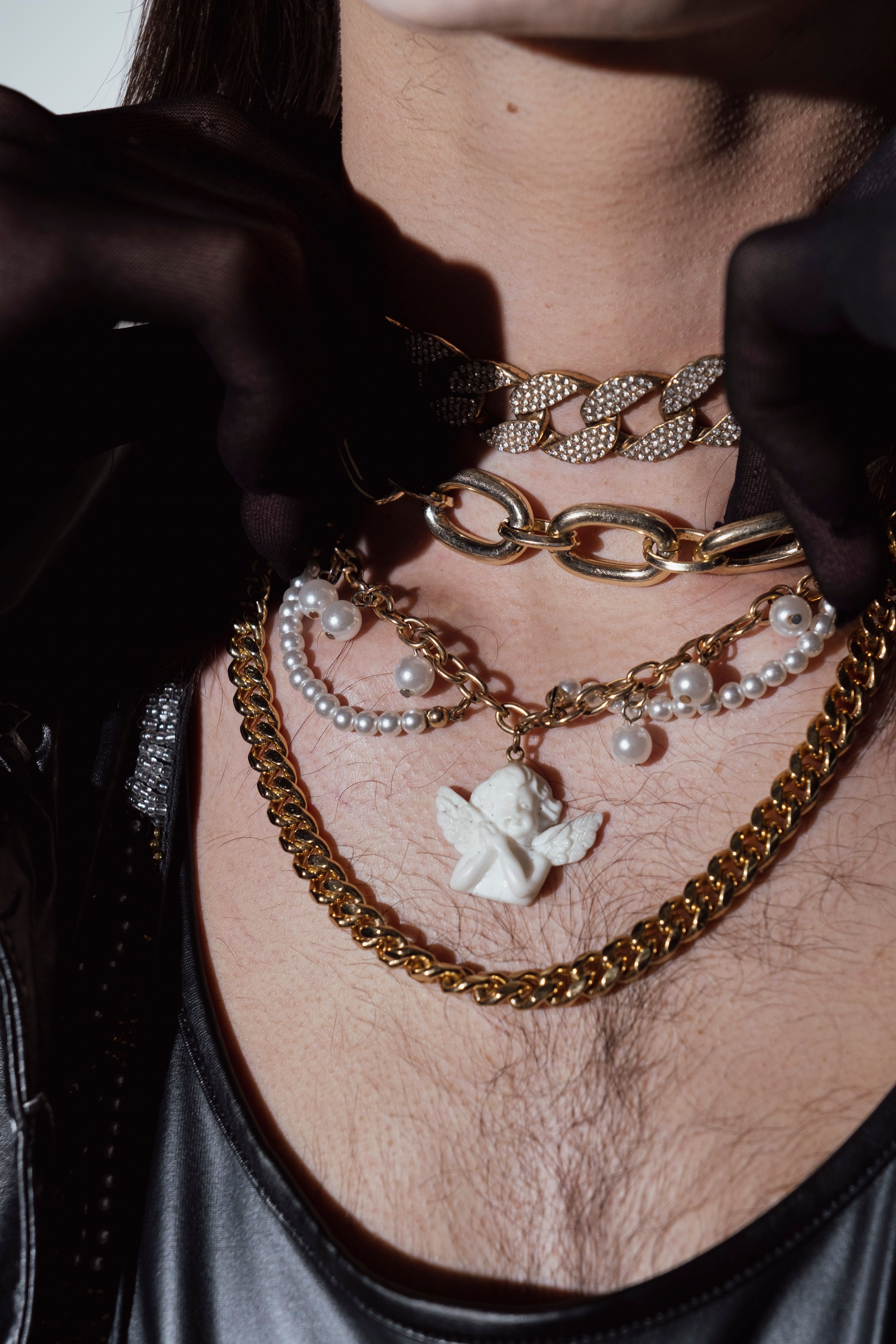A person wearing a necklace with a chain and a chain · Free Stock Photo