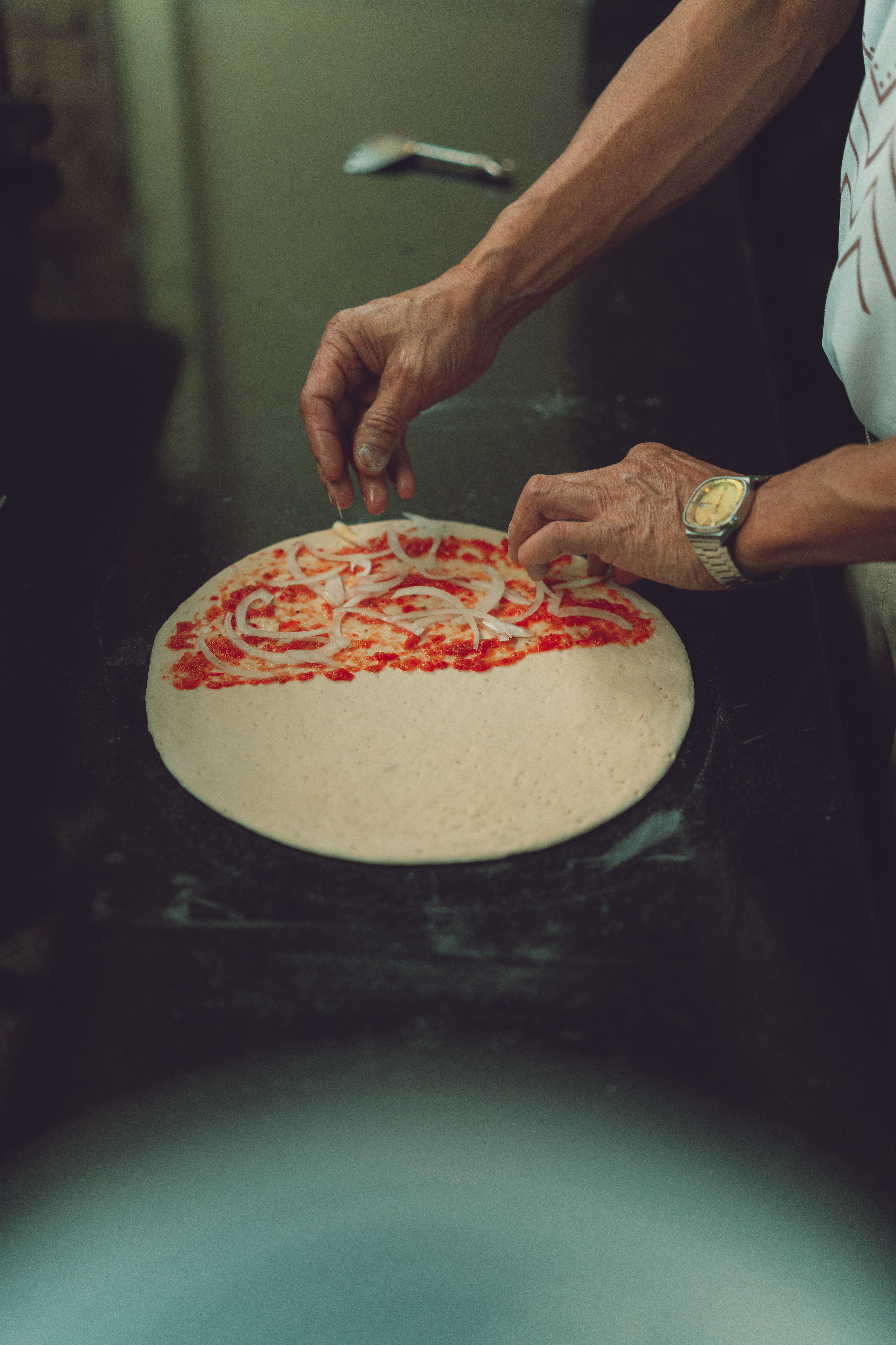 Close-Up Shot of a Person Making Pizza · Free Stock Photo
