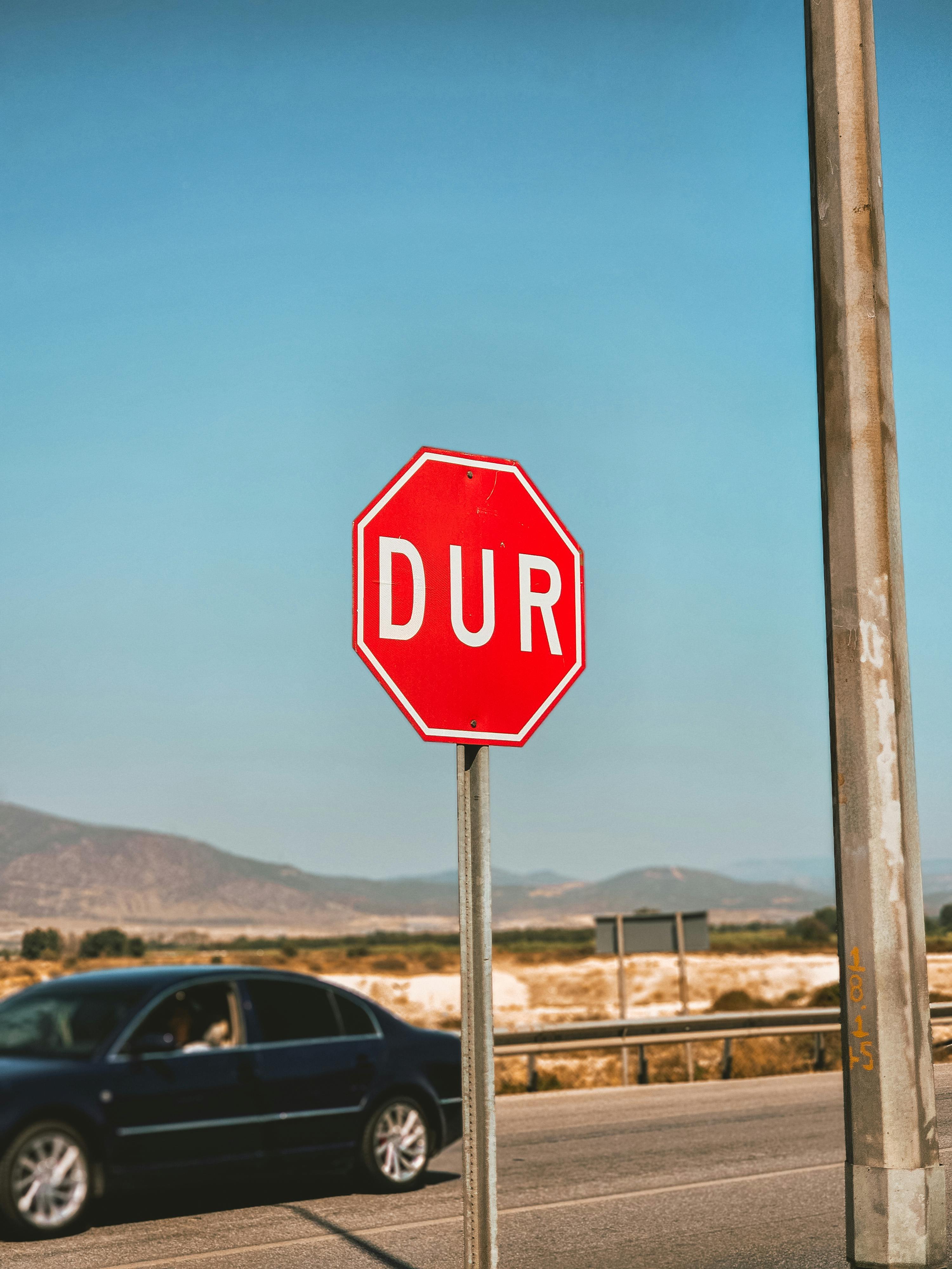 Red Stop Sign 'DUR' on a Rural Road · Free Stock Photo