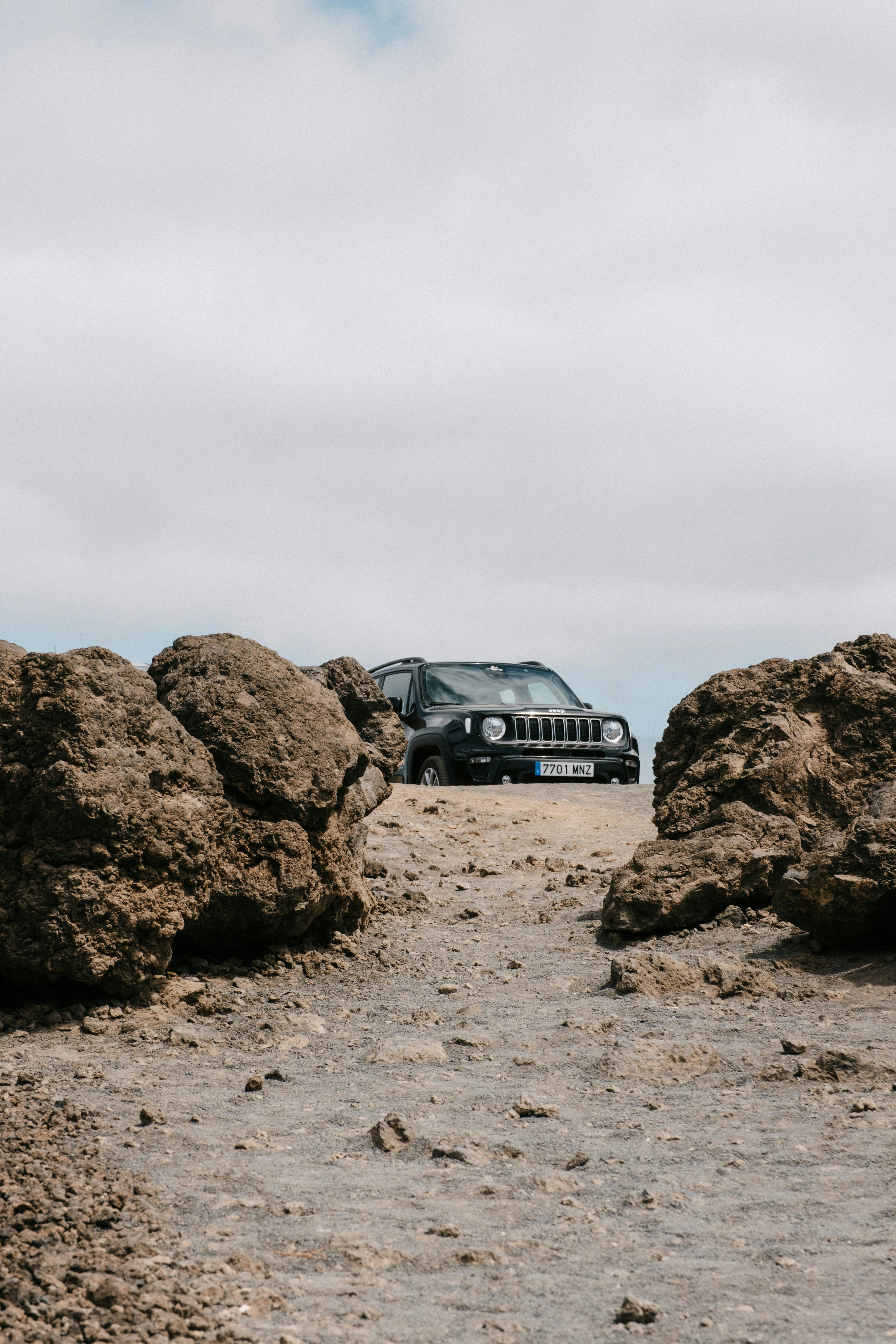 Jeep behind Rocks on Desert · Free Stock Photo