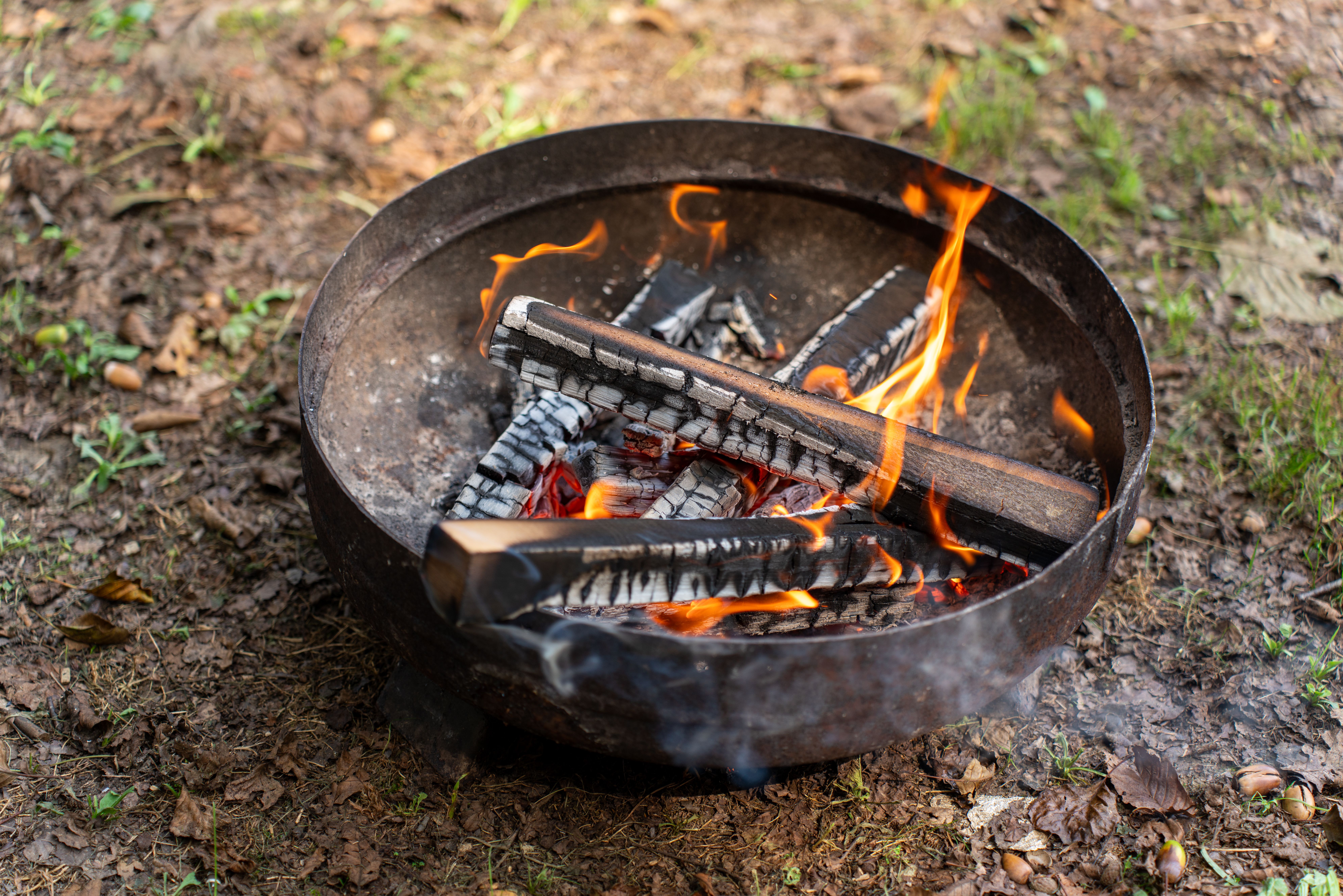 A campfire with a stick and a fire pit · Free Stock Photo