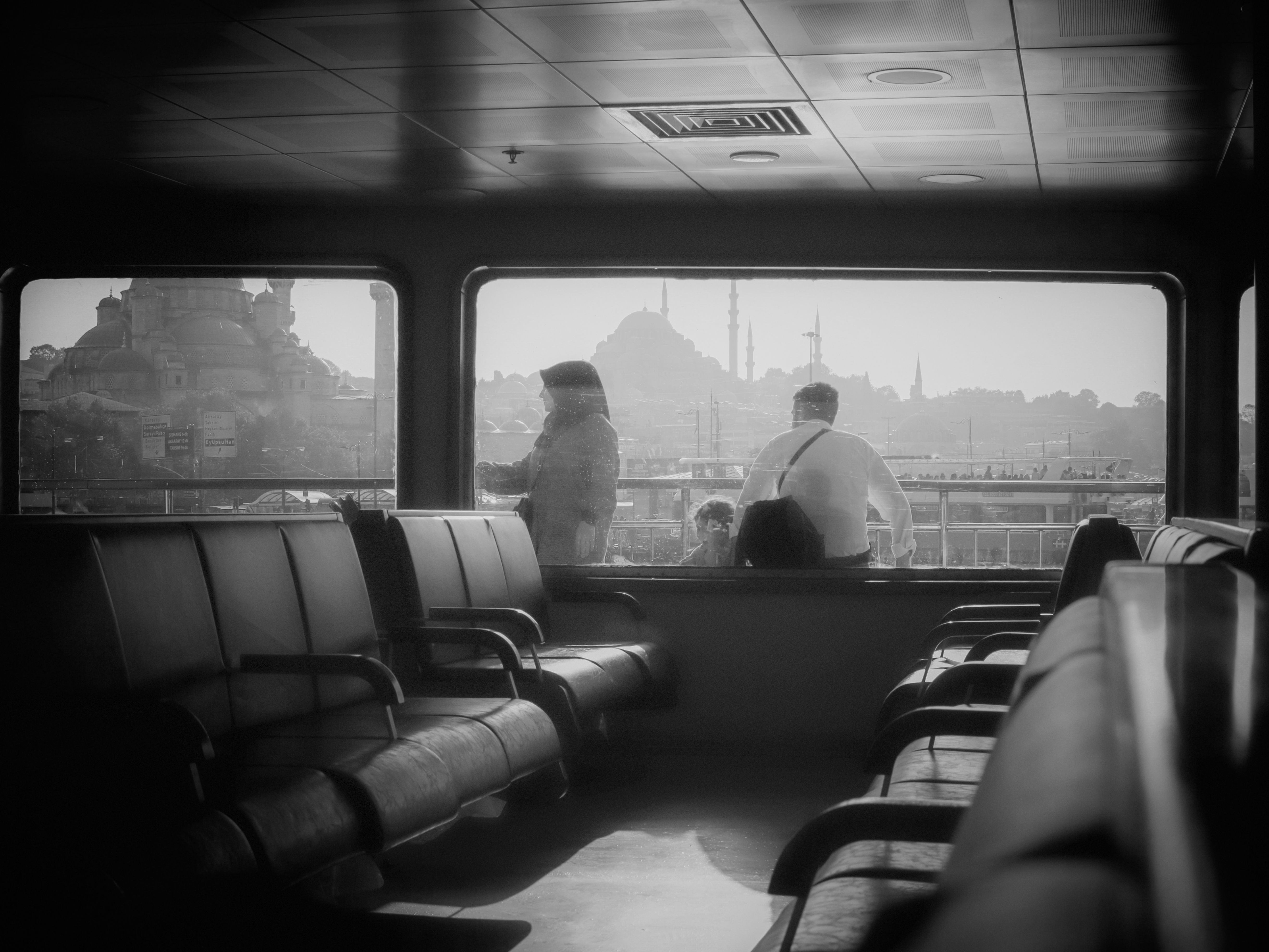 A black and white photo of two people sitting on a bus · Free Stock Photo