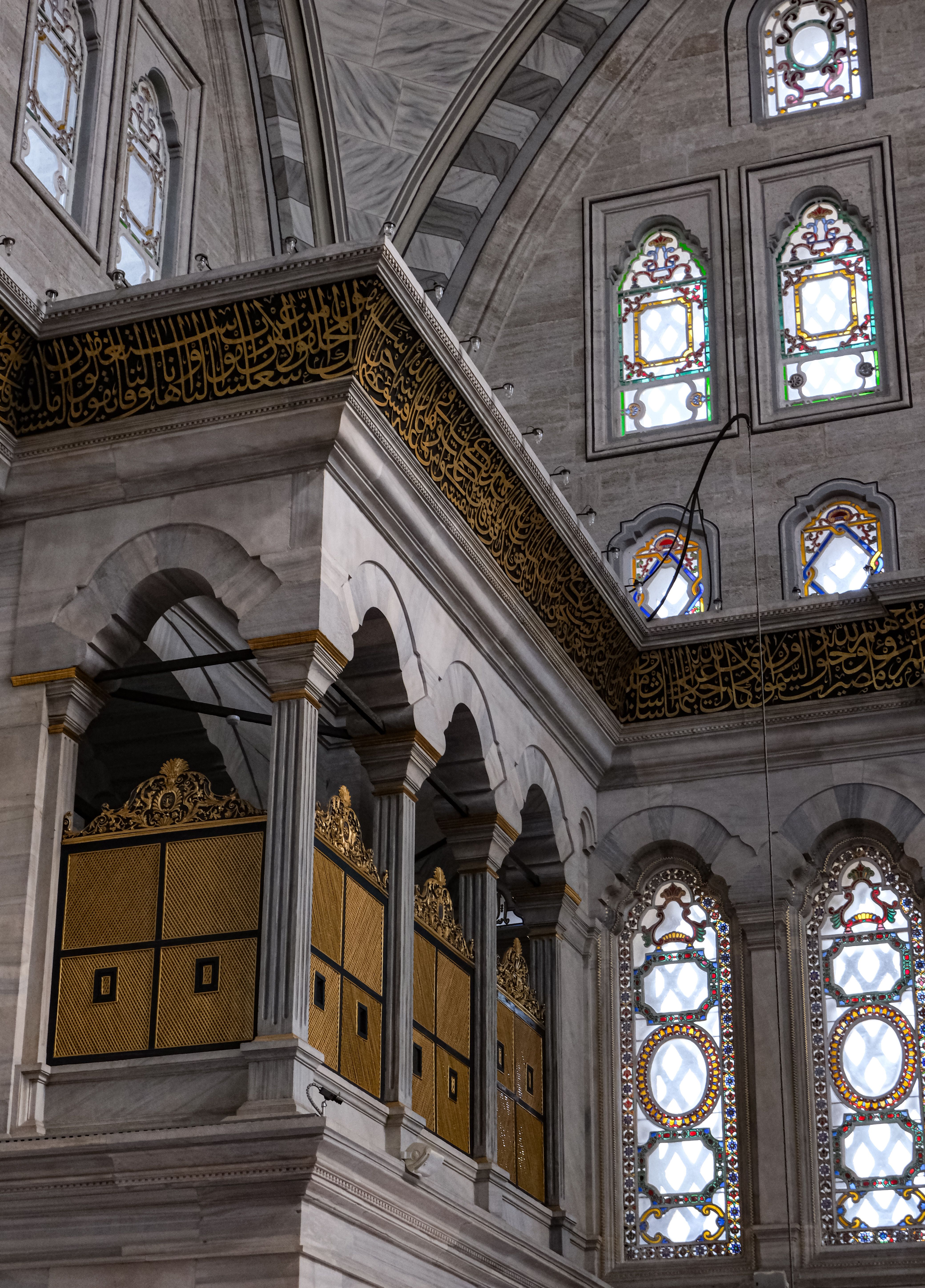 The interior of a church with ornate windows and columns · Free Stock Photo