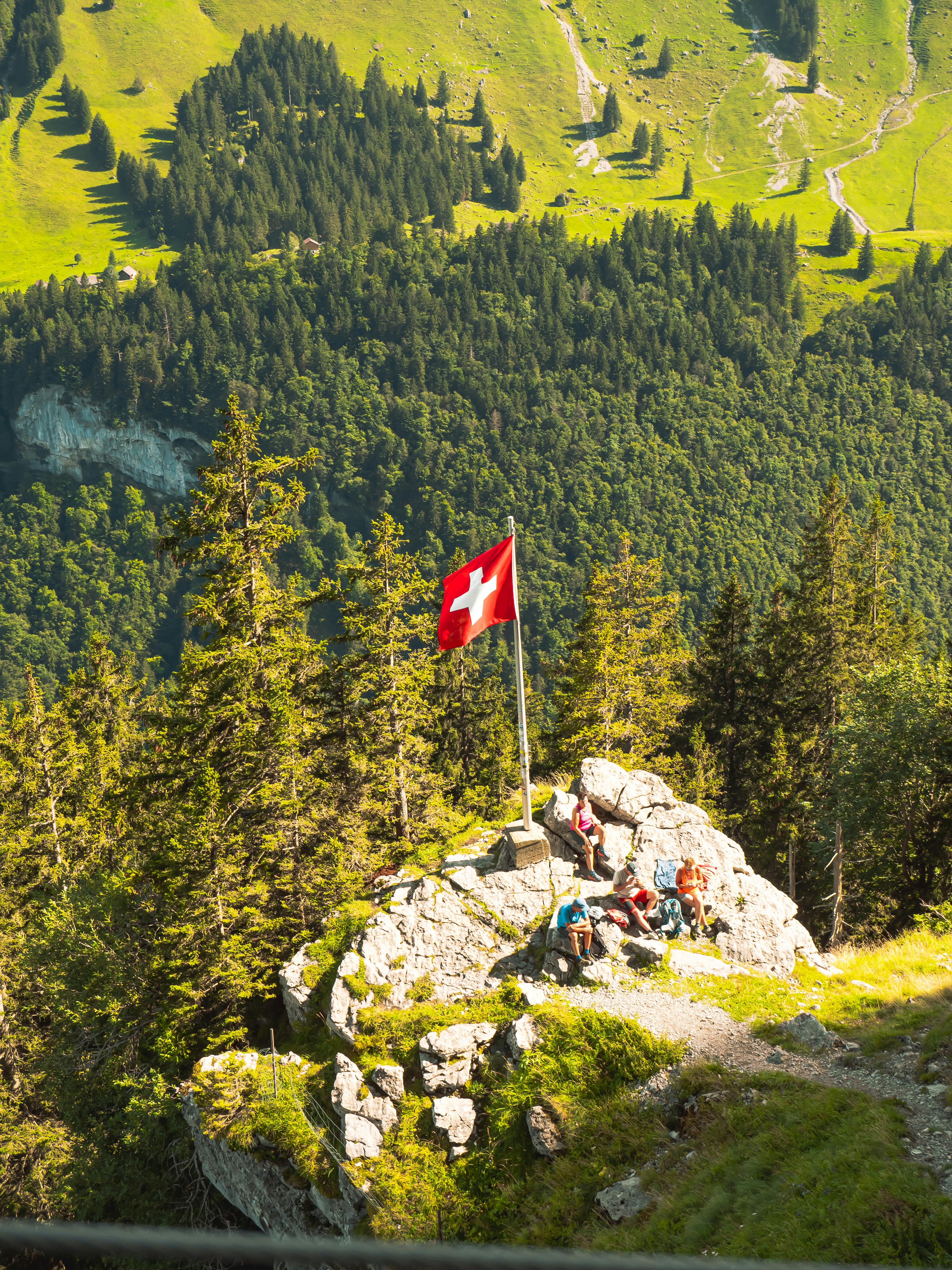 Swiss Flag Flying above Valley in Alps · Free Stock Photo