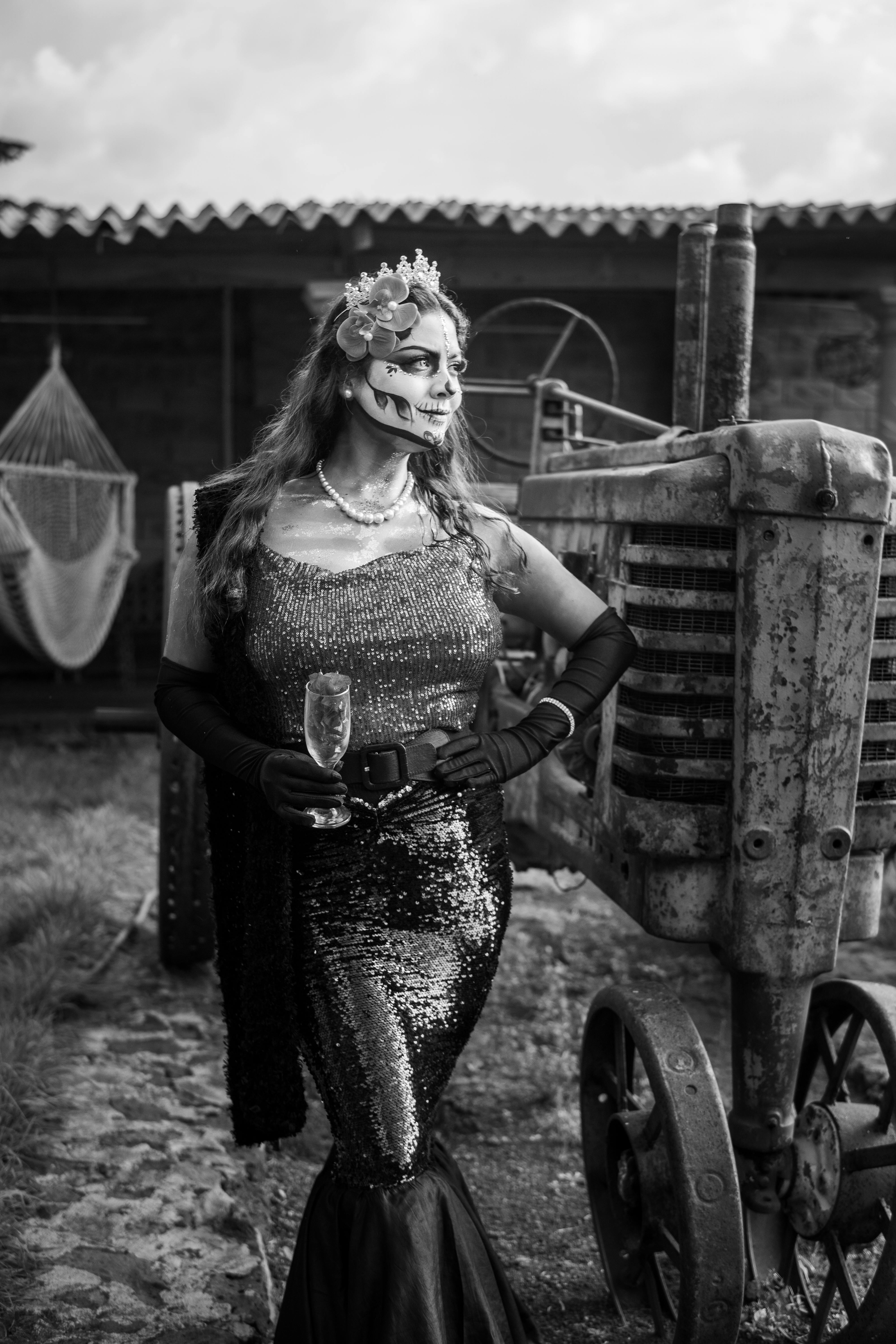 A woman in a sequin dress standing next to a tractor · Free Stock Photo