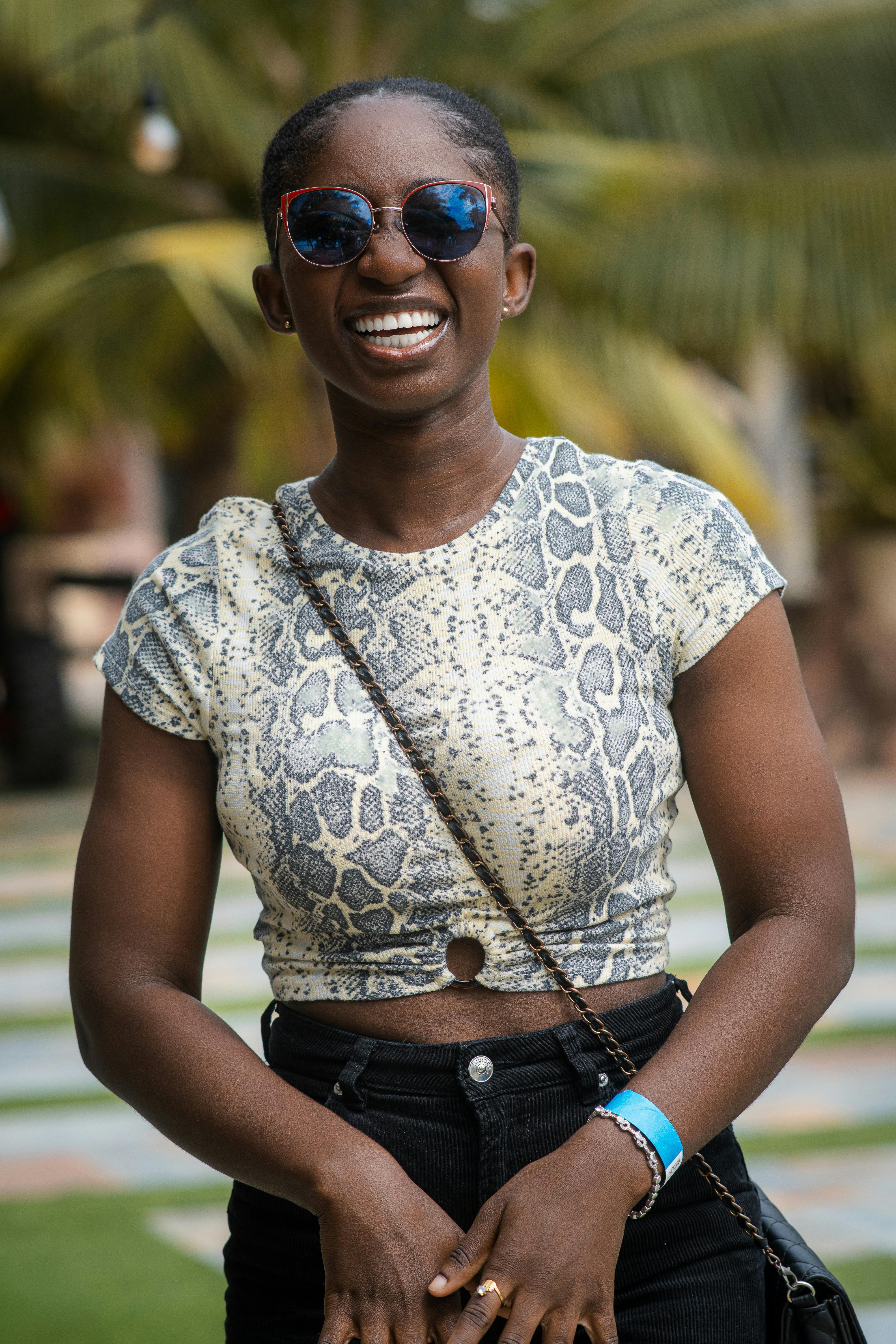 A woman in sunglasses and a snake skin top · Free Stock Photo