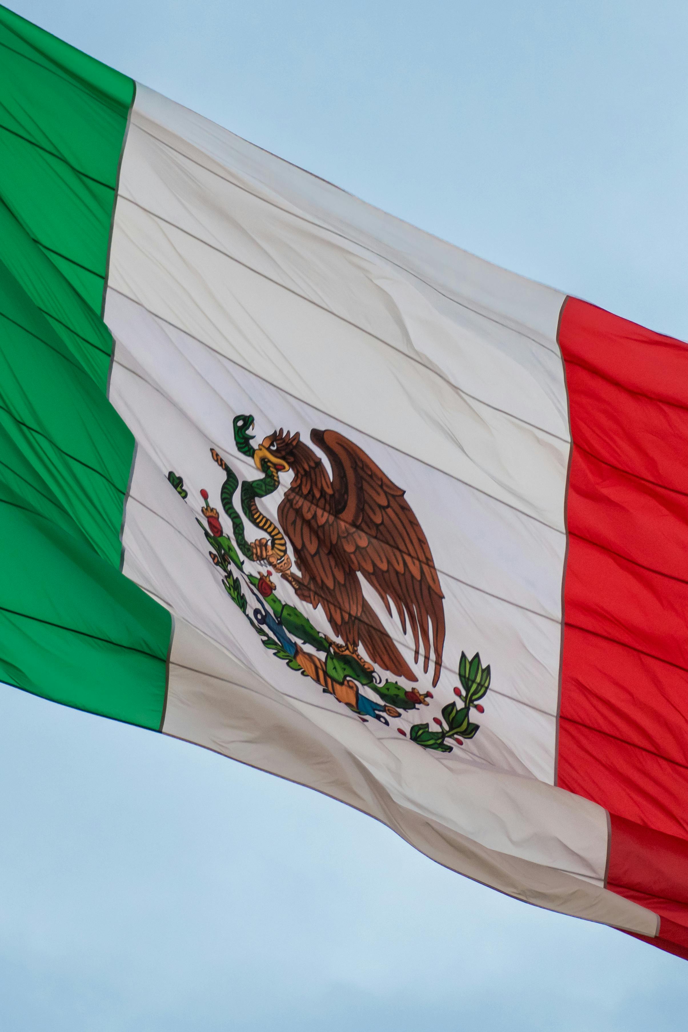 A mexican flag flying in the wind · Free Stock Photo