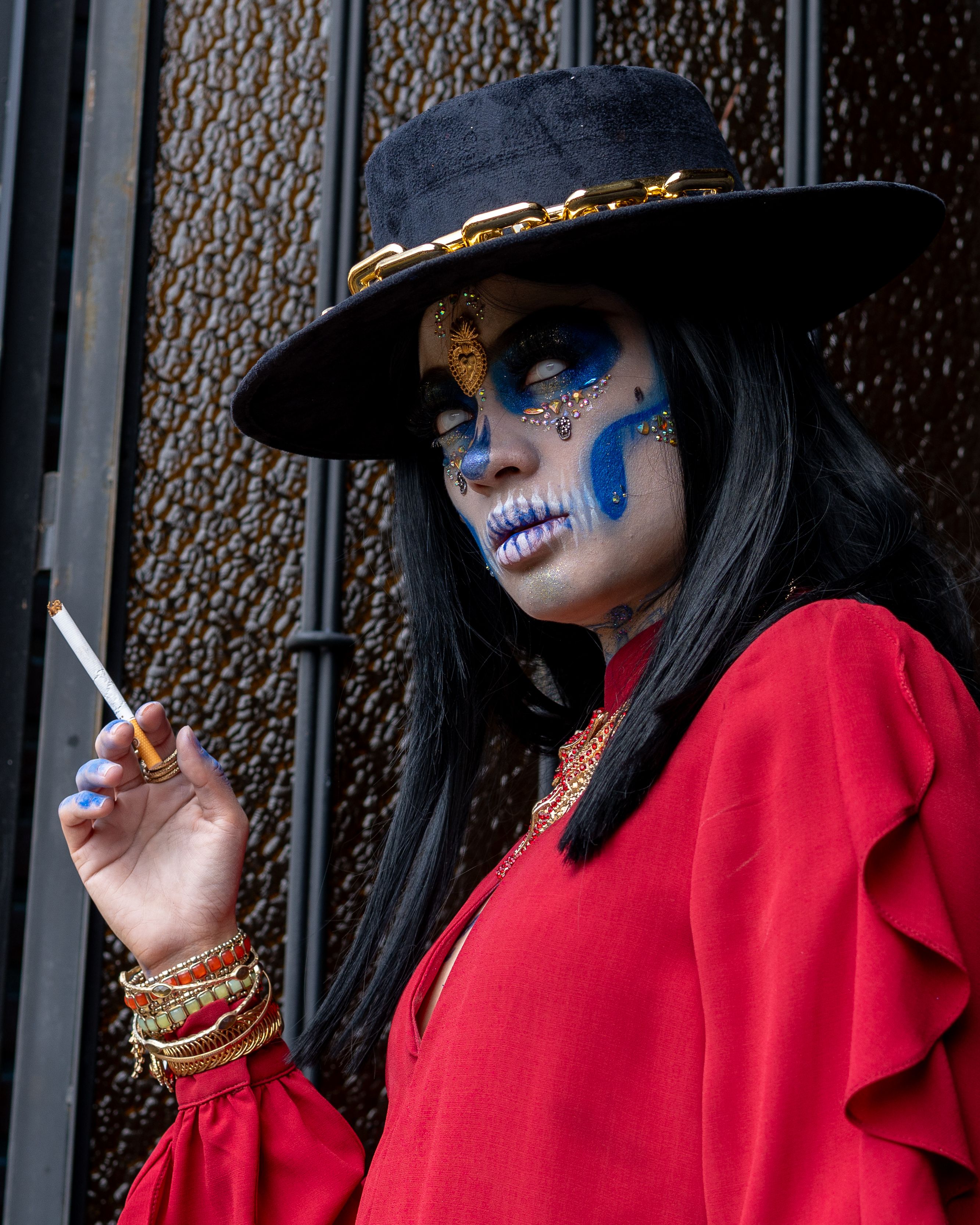 A woman in a blue hat and blue makeup smoking a cigarette · Free Stock ...