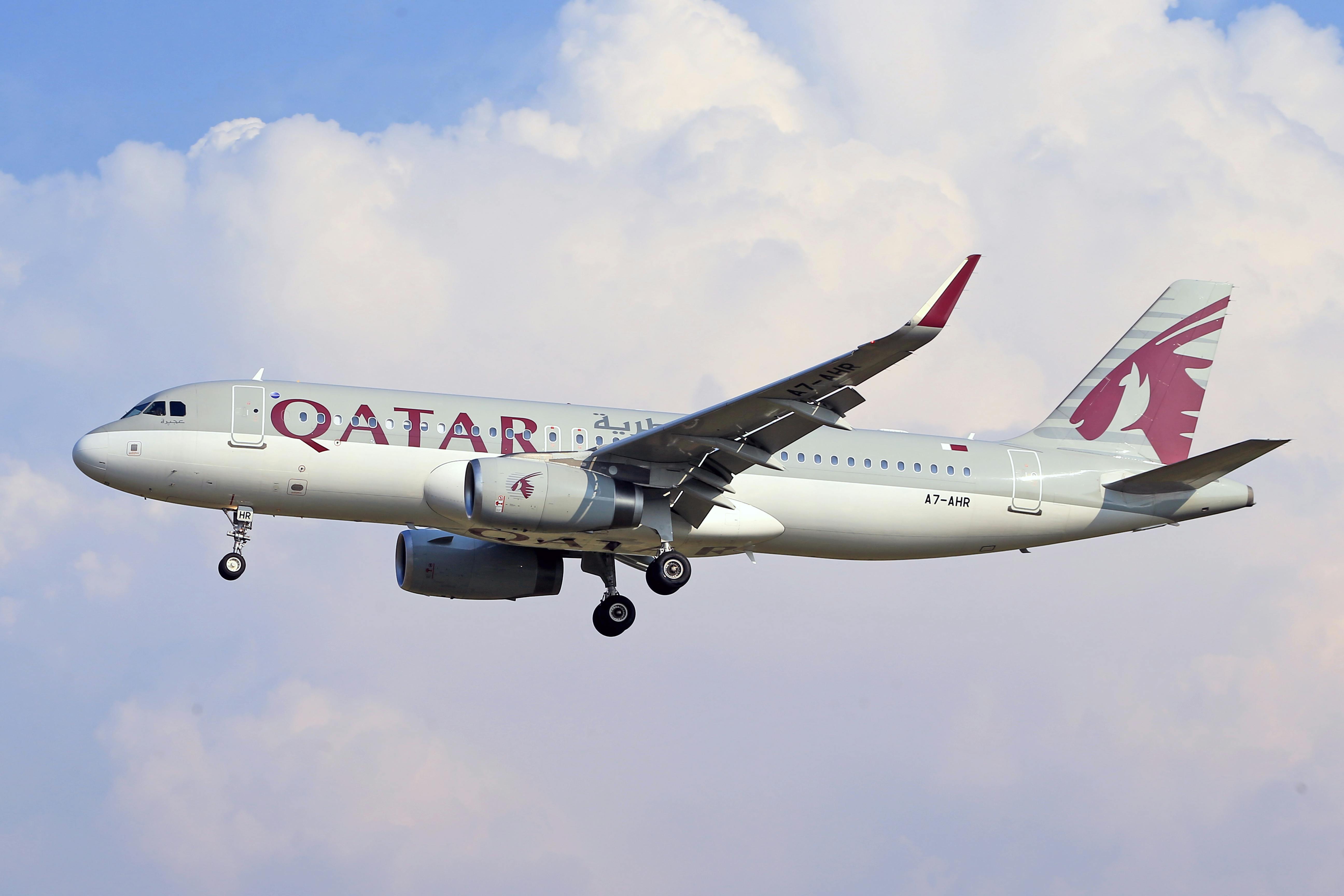 A qatar airways plane flying in the sky · Free Stock Photo