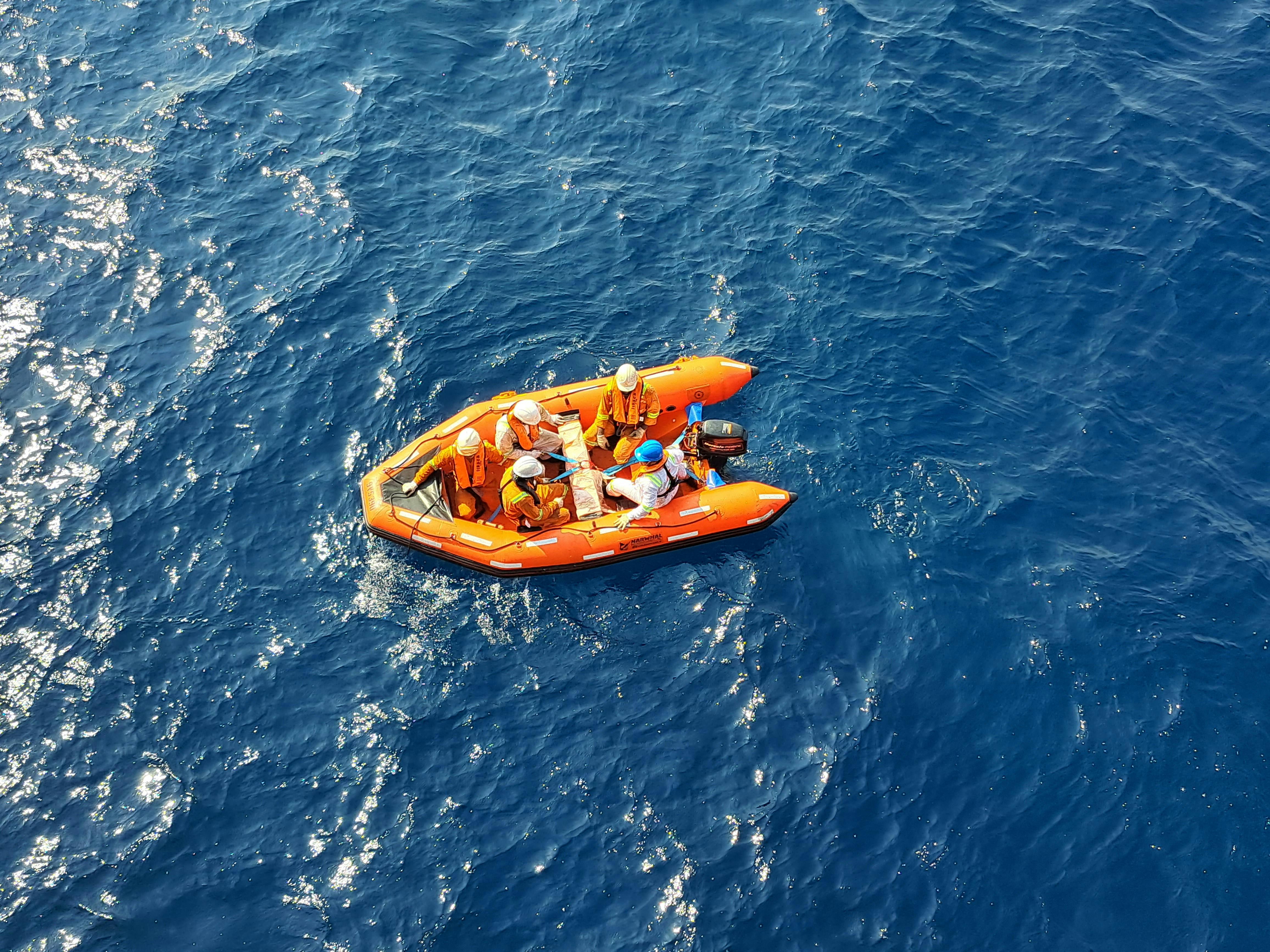 Group of Men on a Lifeboat in the Middle of a Sea · Free Stock Photo