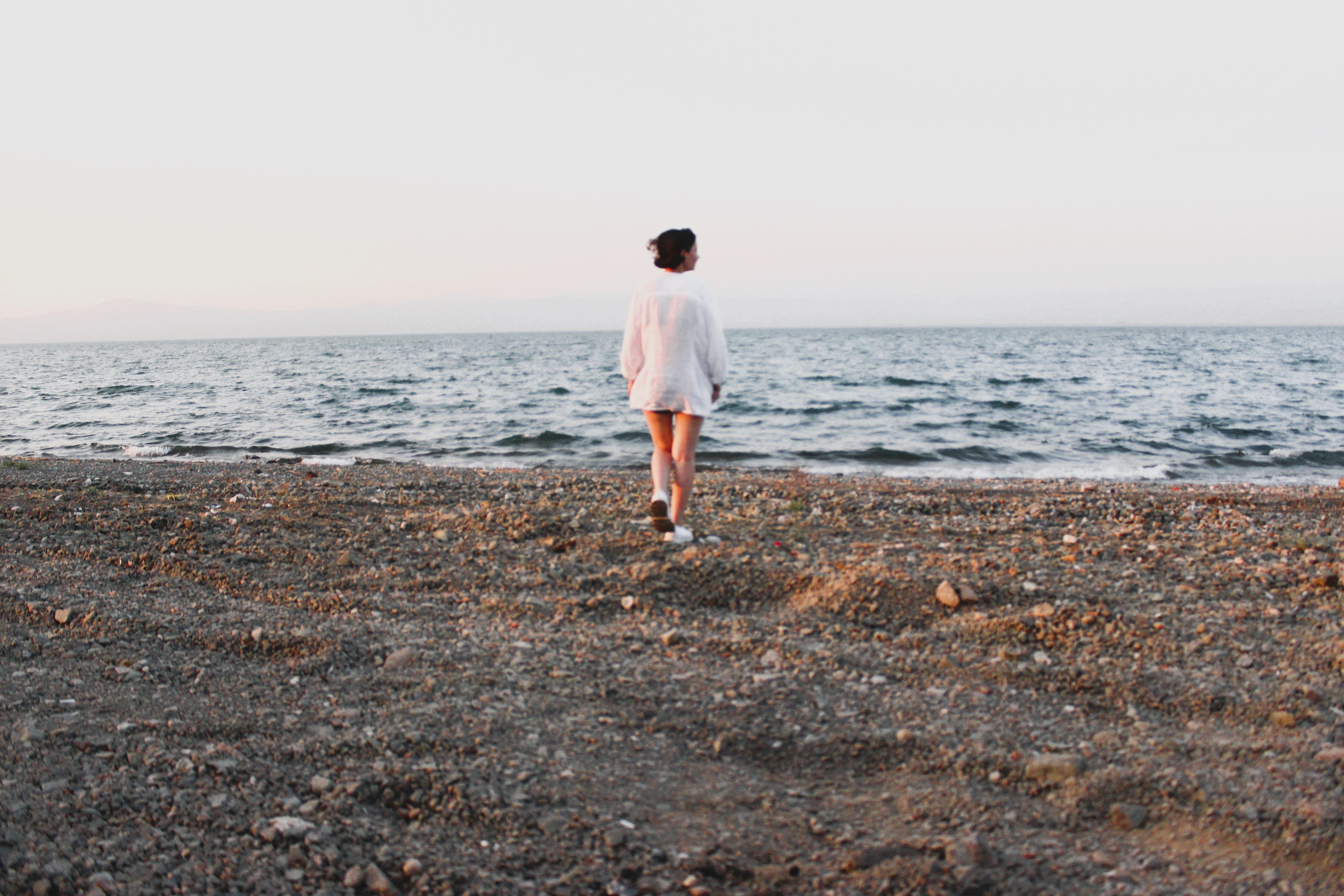 Woman Walking Gravel Beach · Free Stock Photo