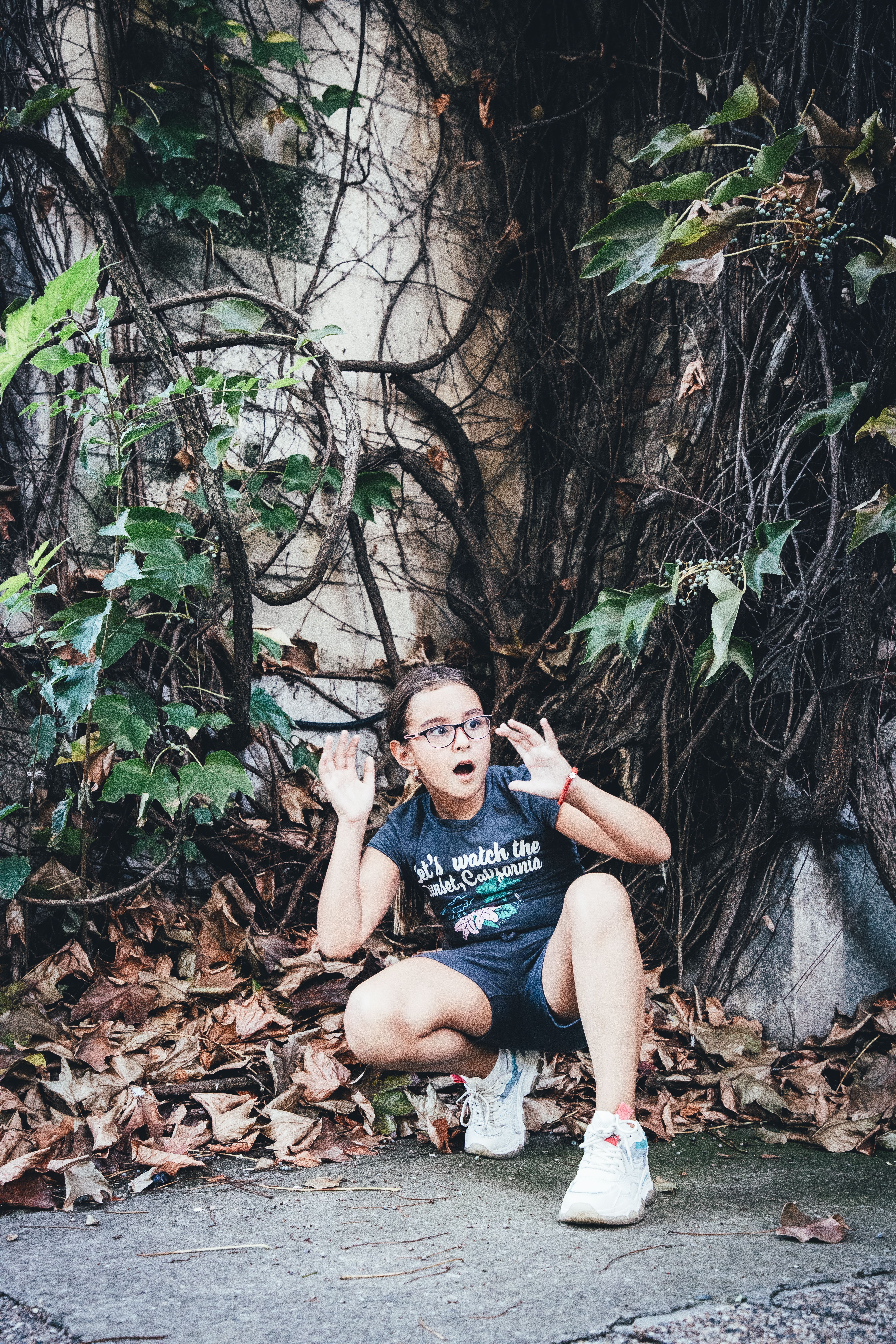 Girl Crouching near Tree Roots · Free Stock Photo