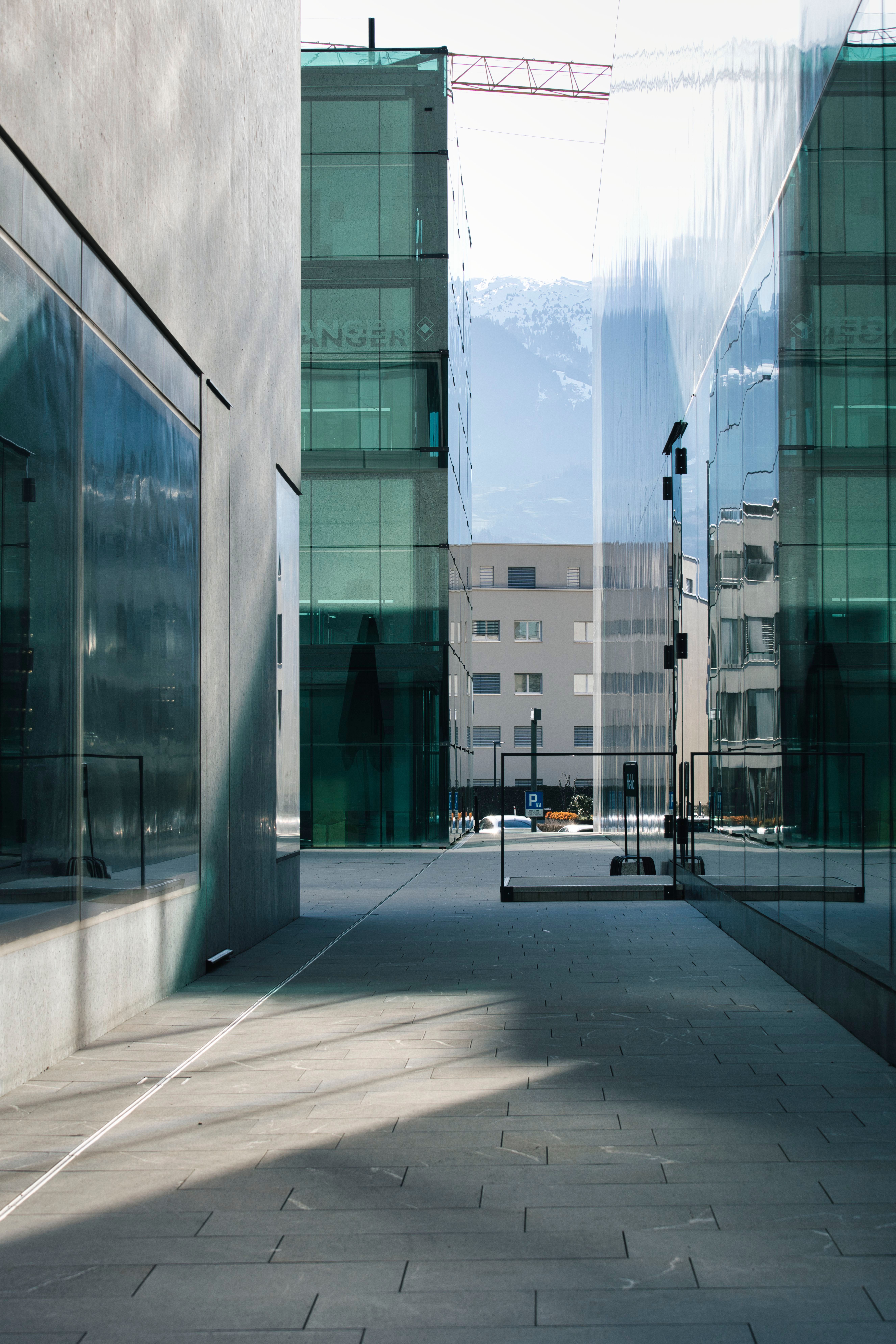 A walkway in a modern building with glass walls · Free Stock Photo
