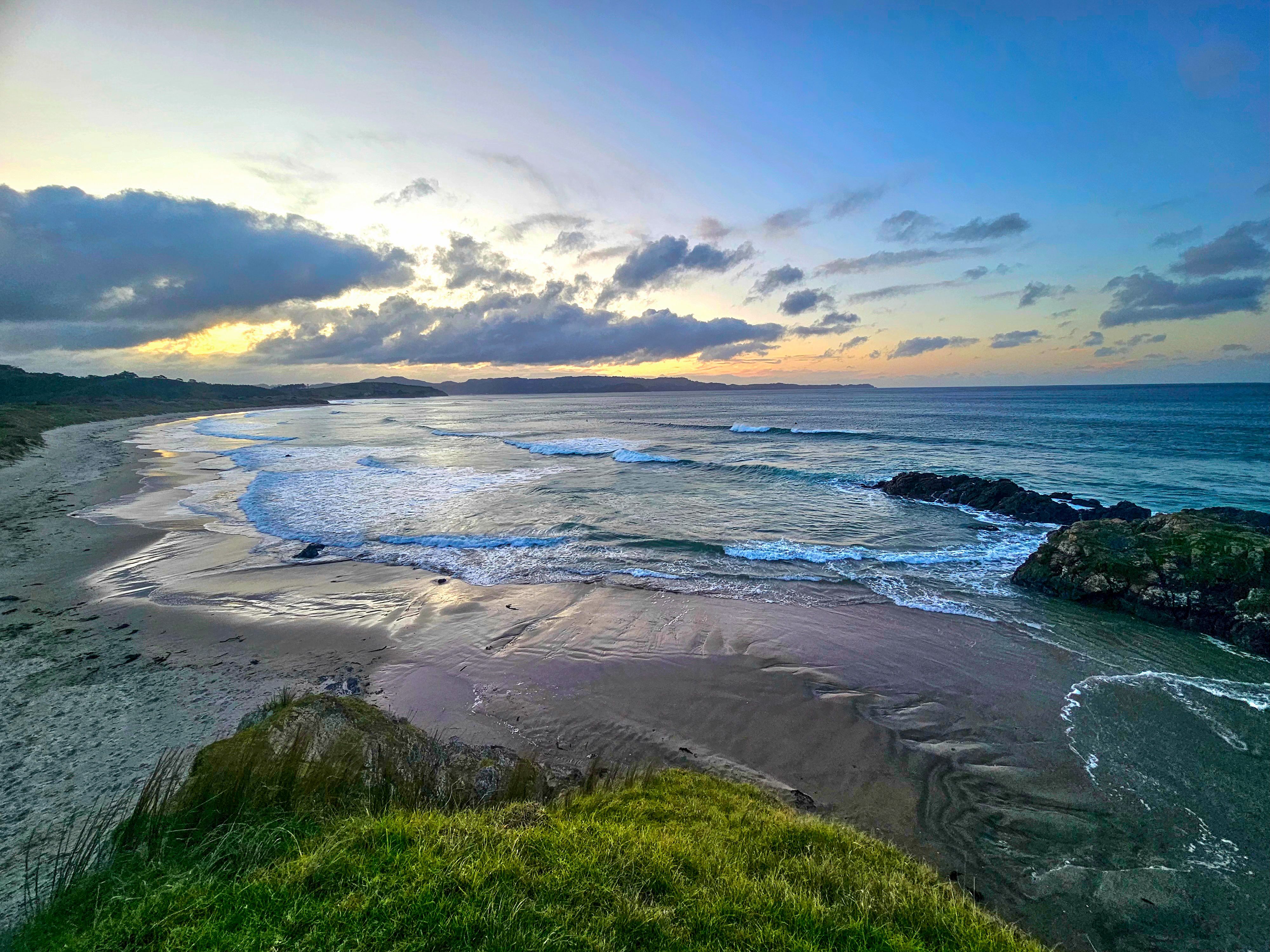 A sunset view of a beach and ocean · Free Stock Photo