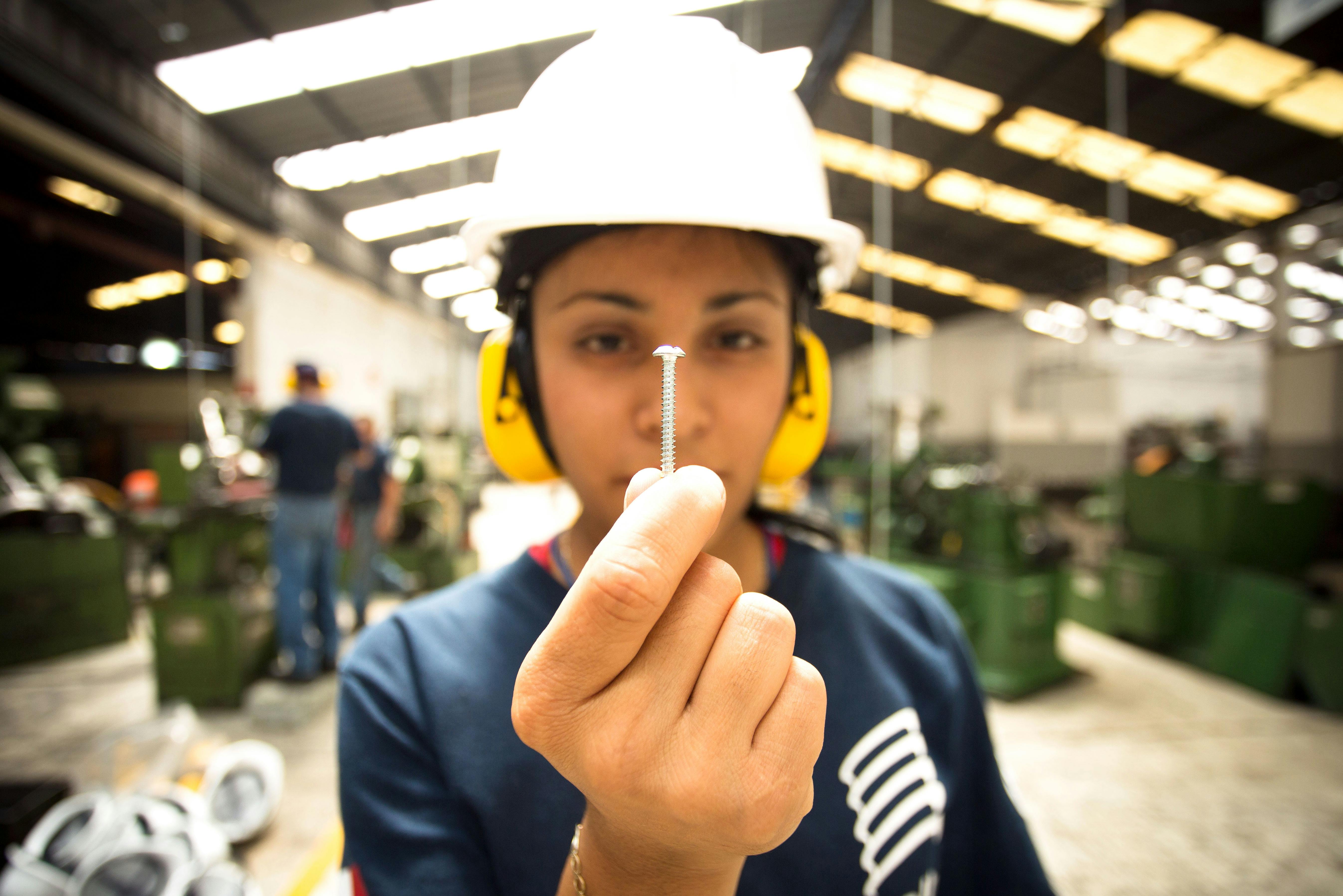 Focused Industrial Worker Holding a Screw · Free Stock Photo
