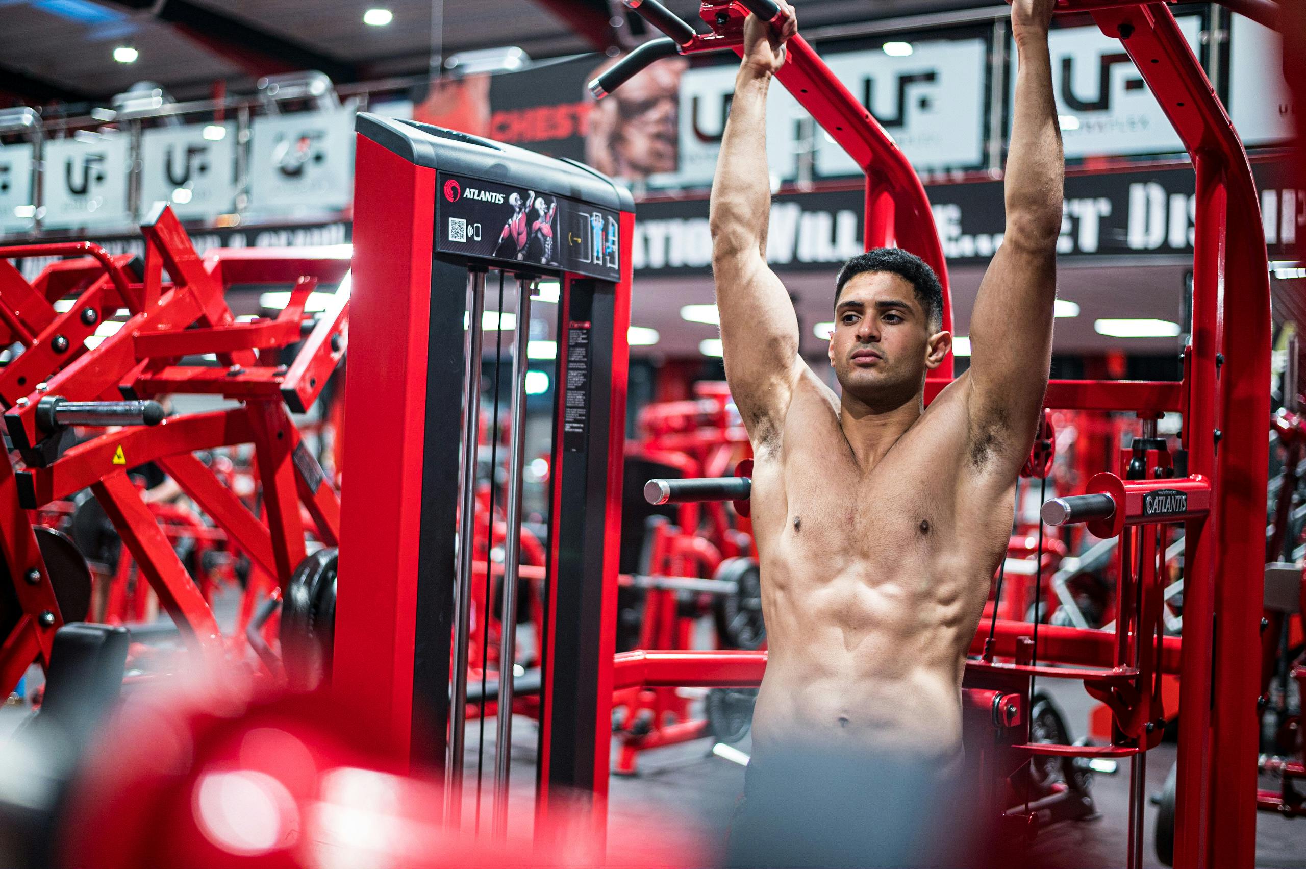 A Shirtless, Muscular Man Exercising at the Gym · Free Stock Photo