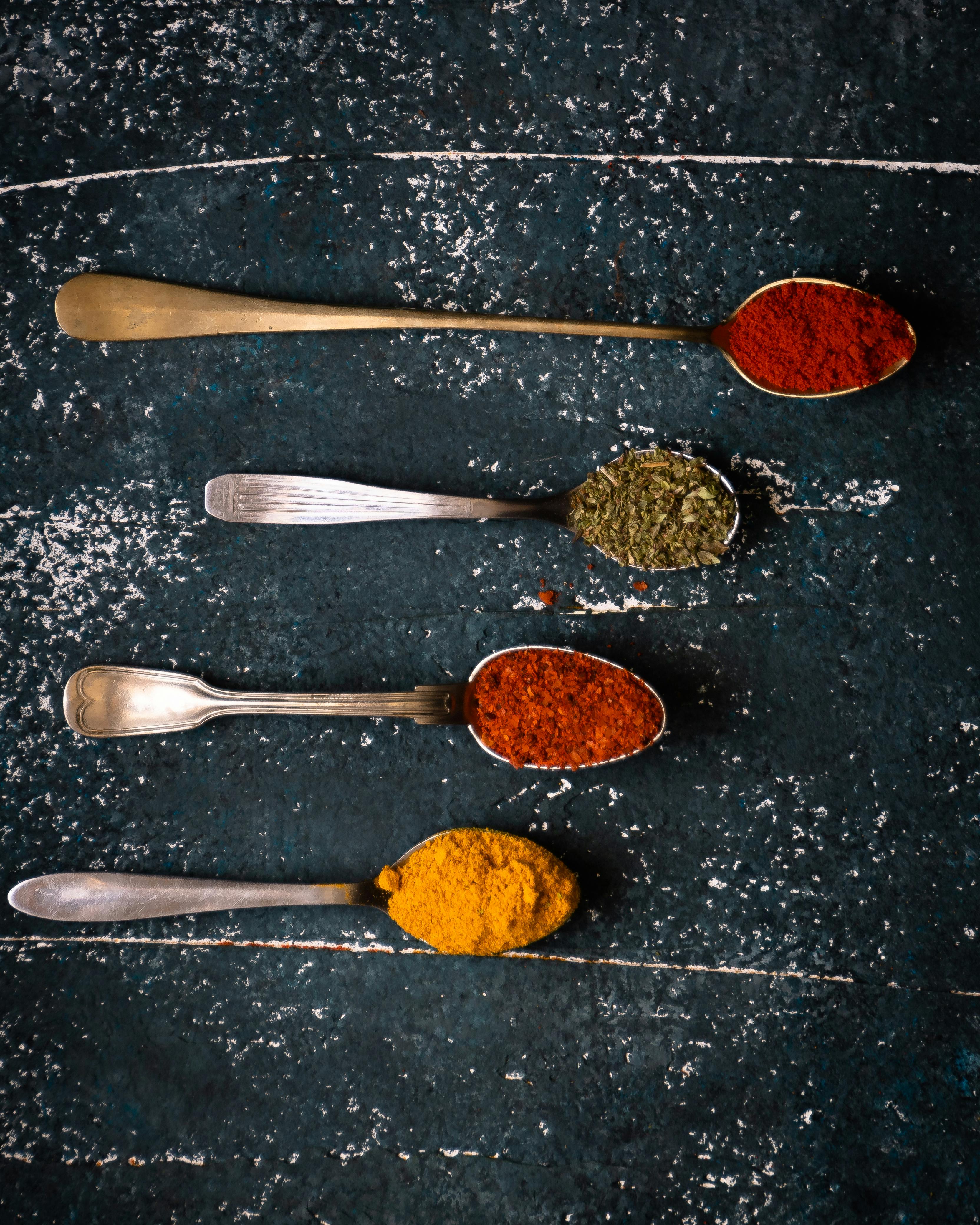 Four Assorted Spices on Brown Wooden Spoon · Free Stock Photo
