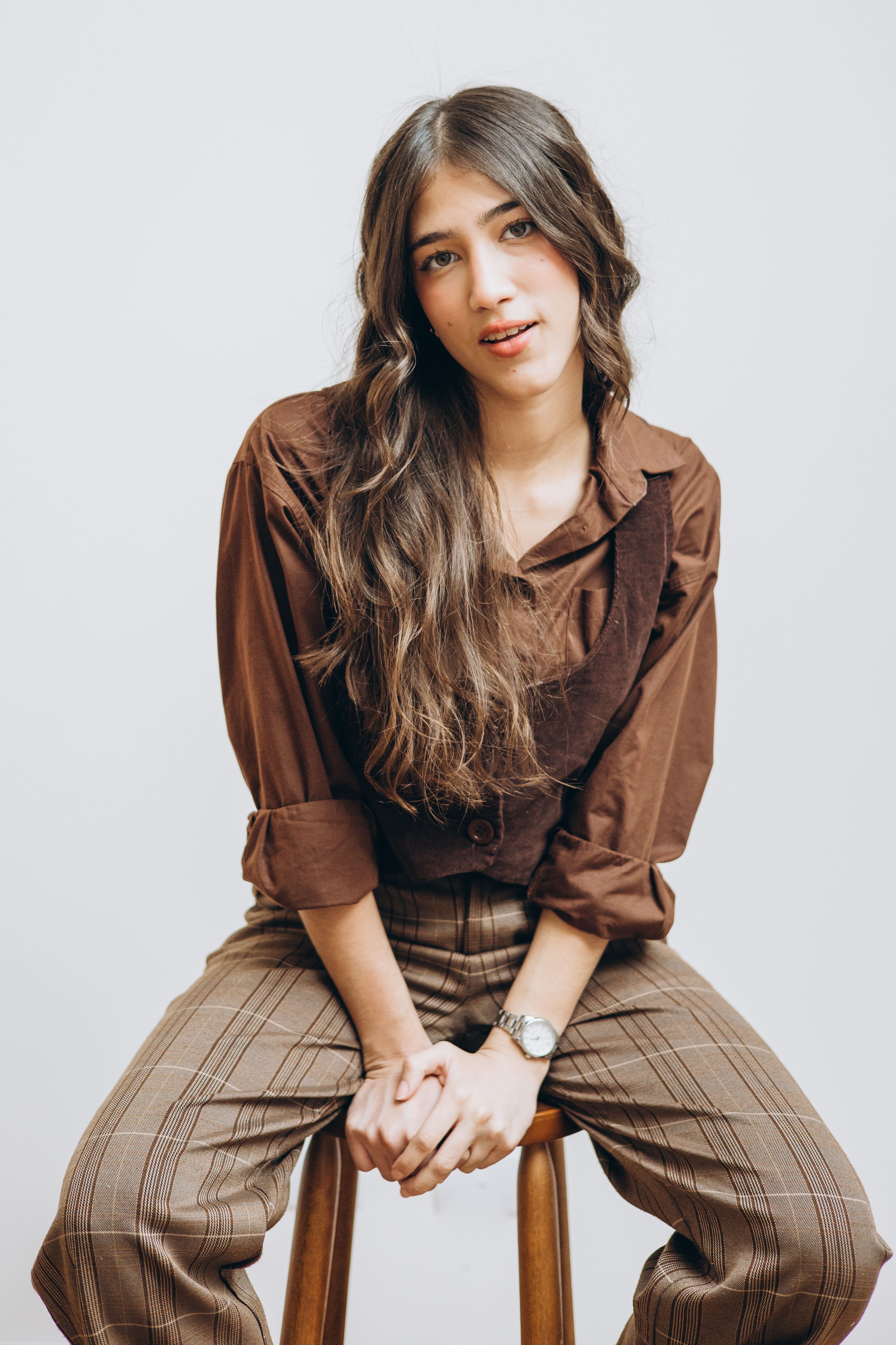 Long-Haired Brunette Wearing a Brown Top Sitting on a Stool · Free ...