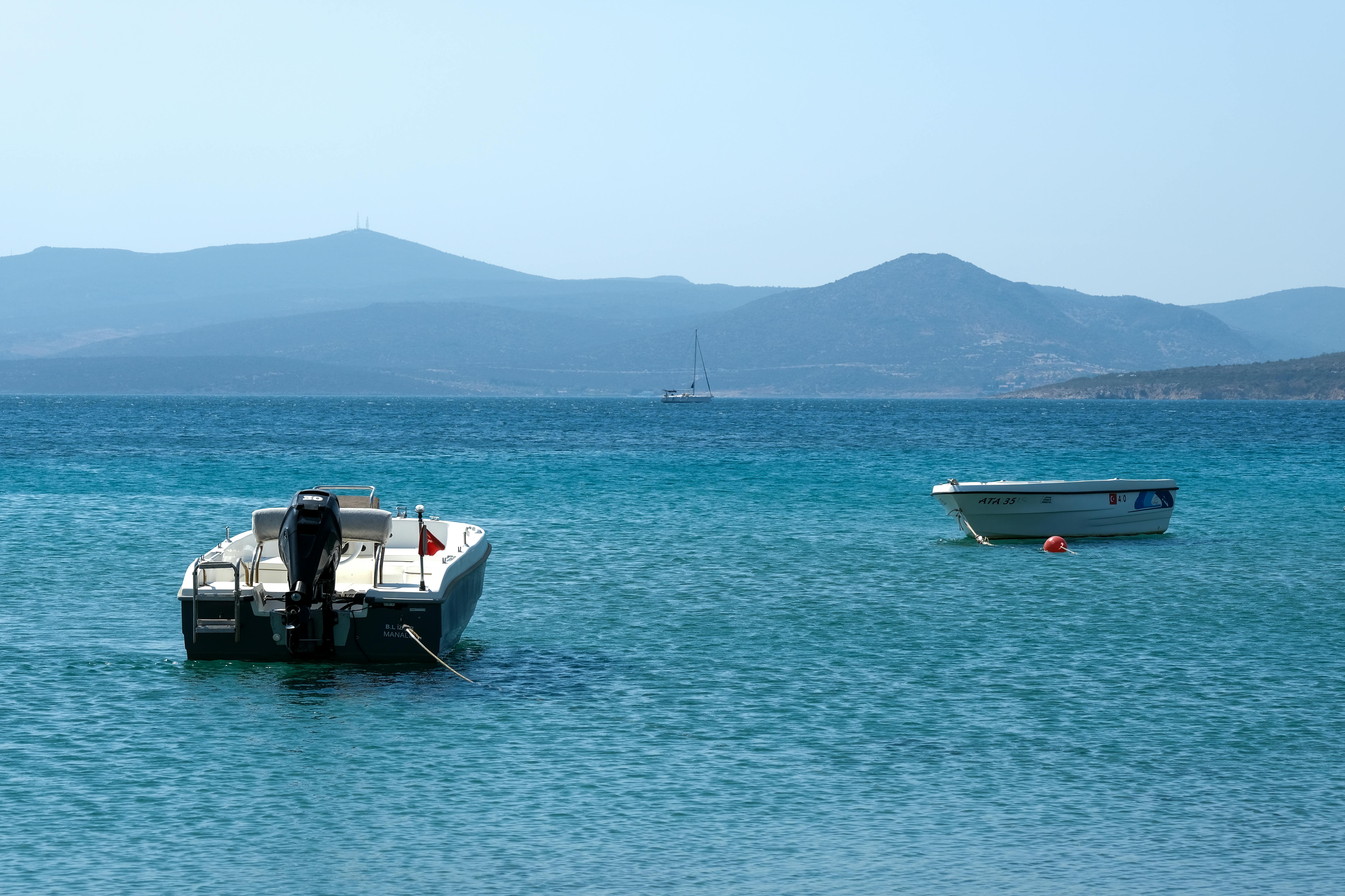 Small Boat Anchored in Tranquil Blue Waters on a Sunny Day · Free Stock ...