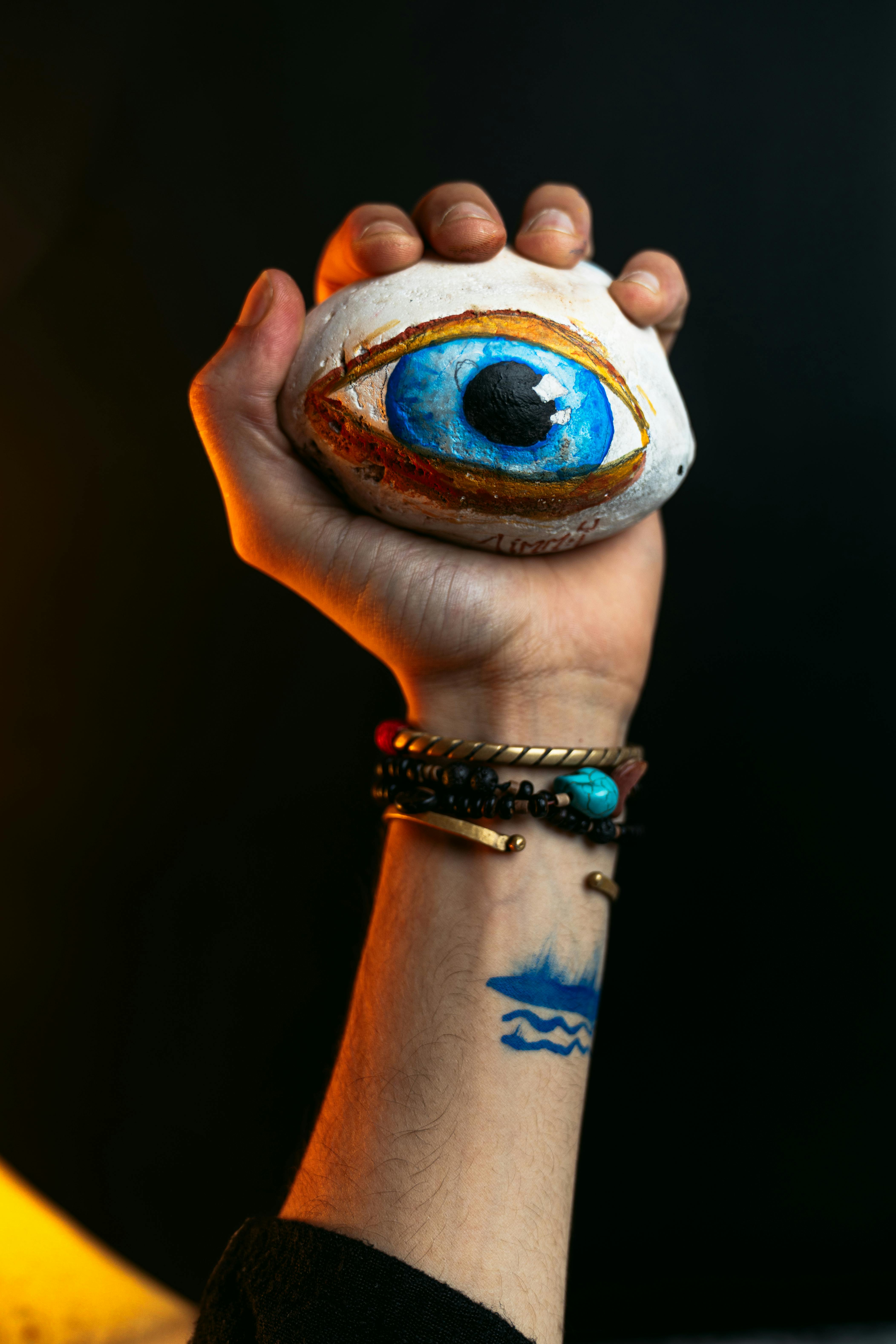 Hand Holding Artistic Eye Sculpture with Bracelet · Free Stock Photo