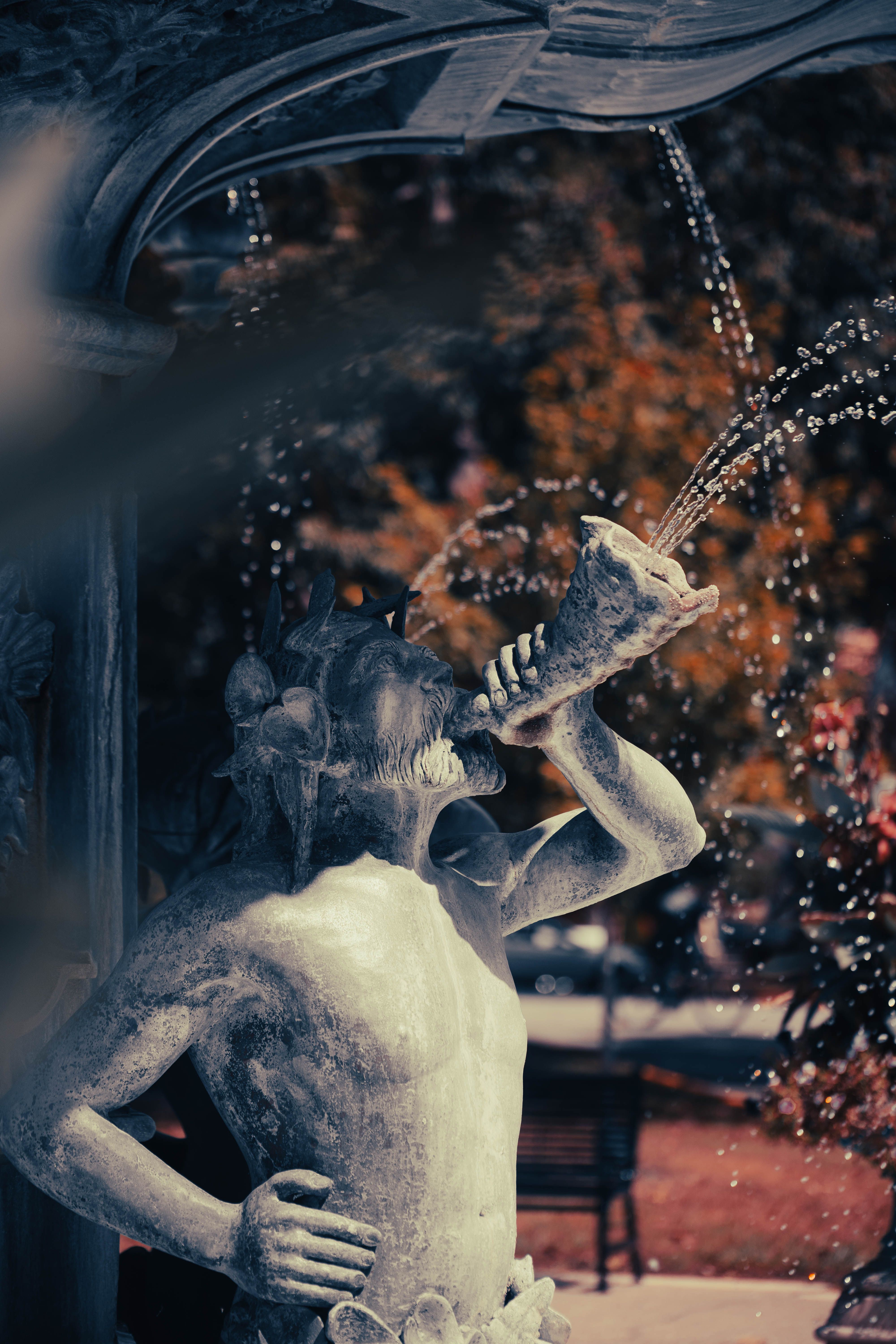 A statue of a man drinking water from a fountain · Free Stock Photo