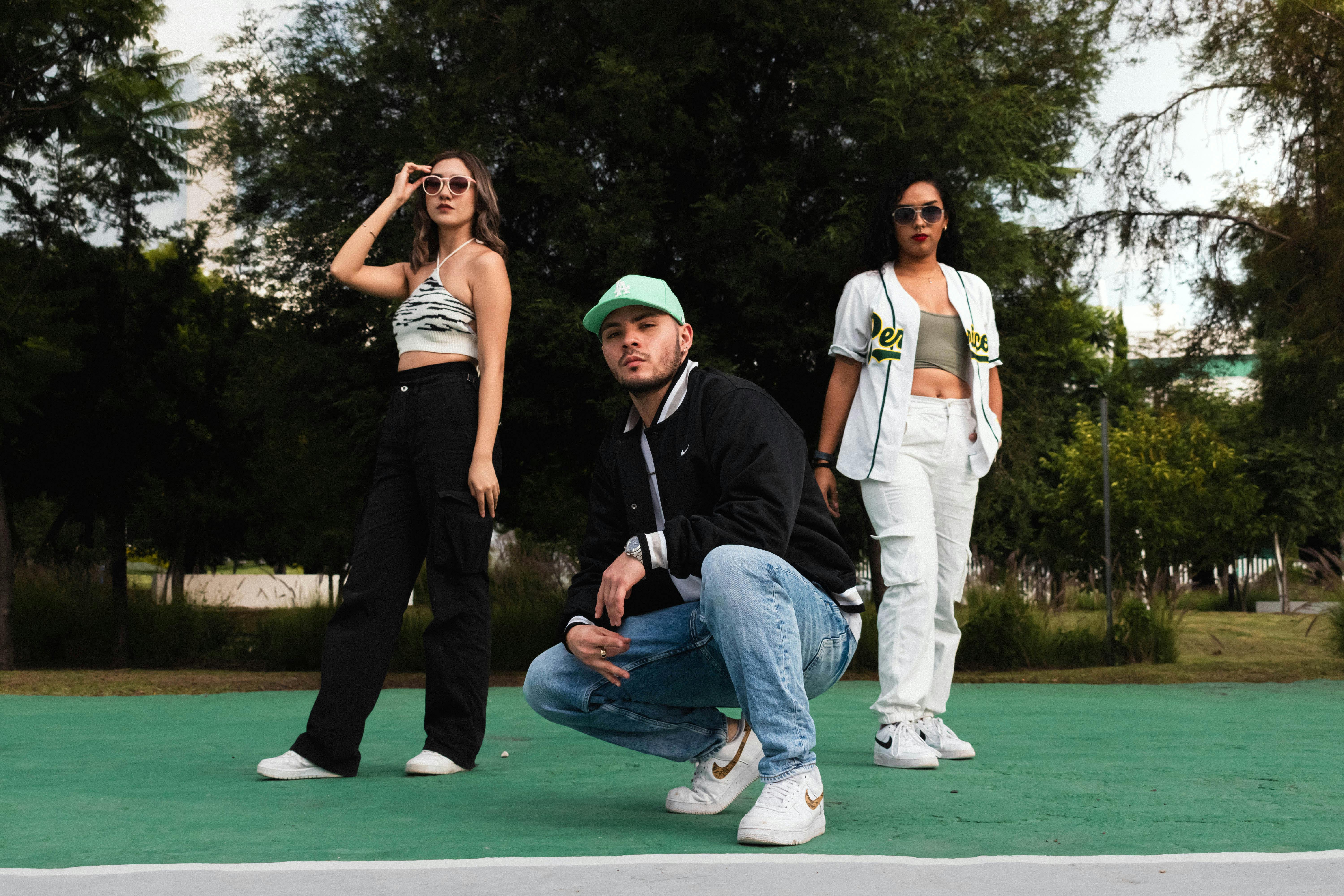 Three people posing for a photo in a park · Free Stock Photo