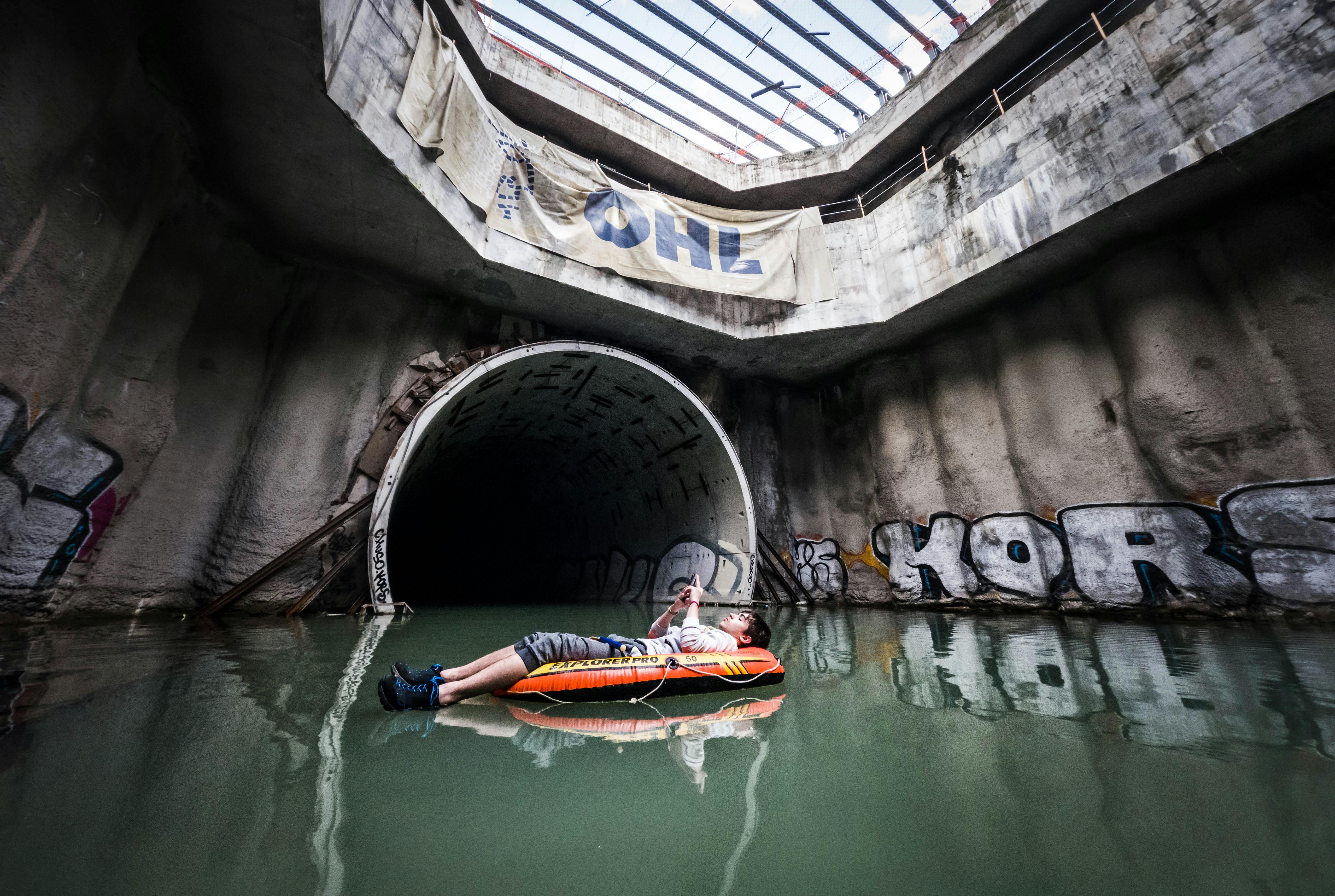Man on Pontoon in Sewer Tunnel · Free Stock Photo