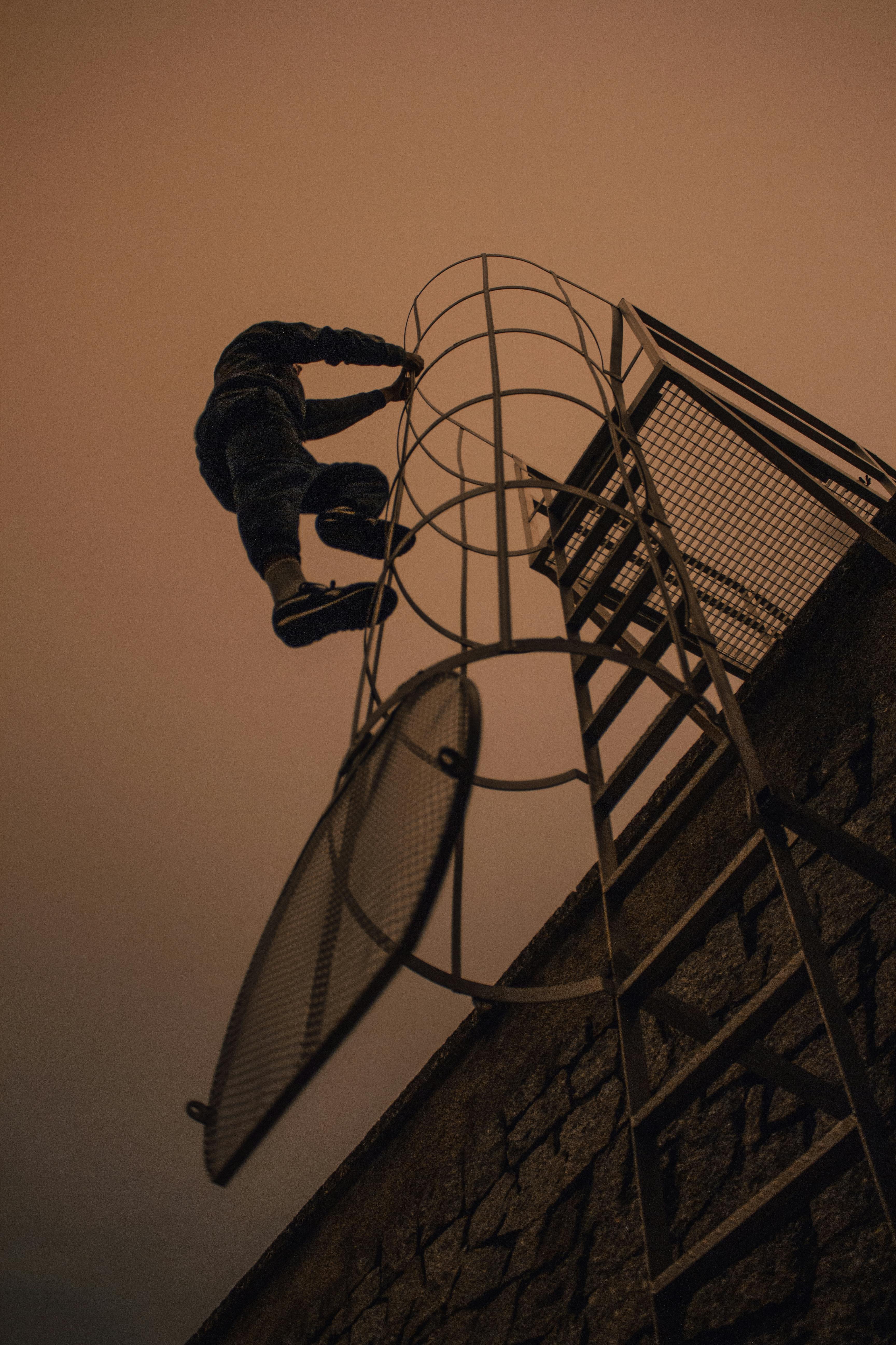 Person Climbing a Metal Ladder · Free Stock Photo