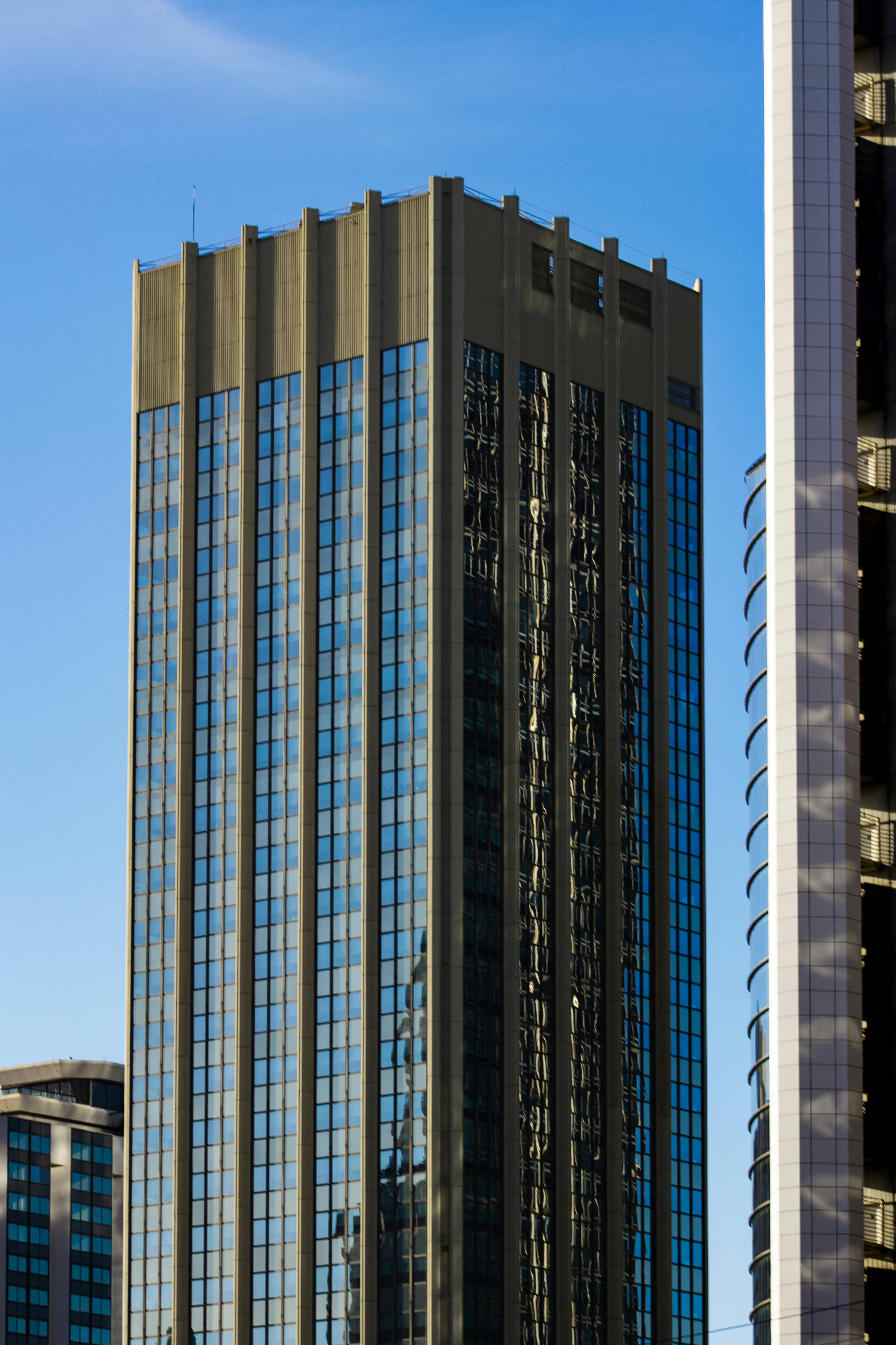 A tall building with windows and a blue sky · Free Stock Photo
