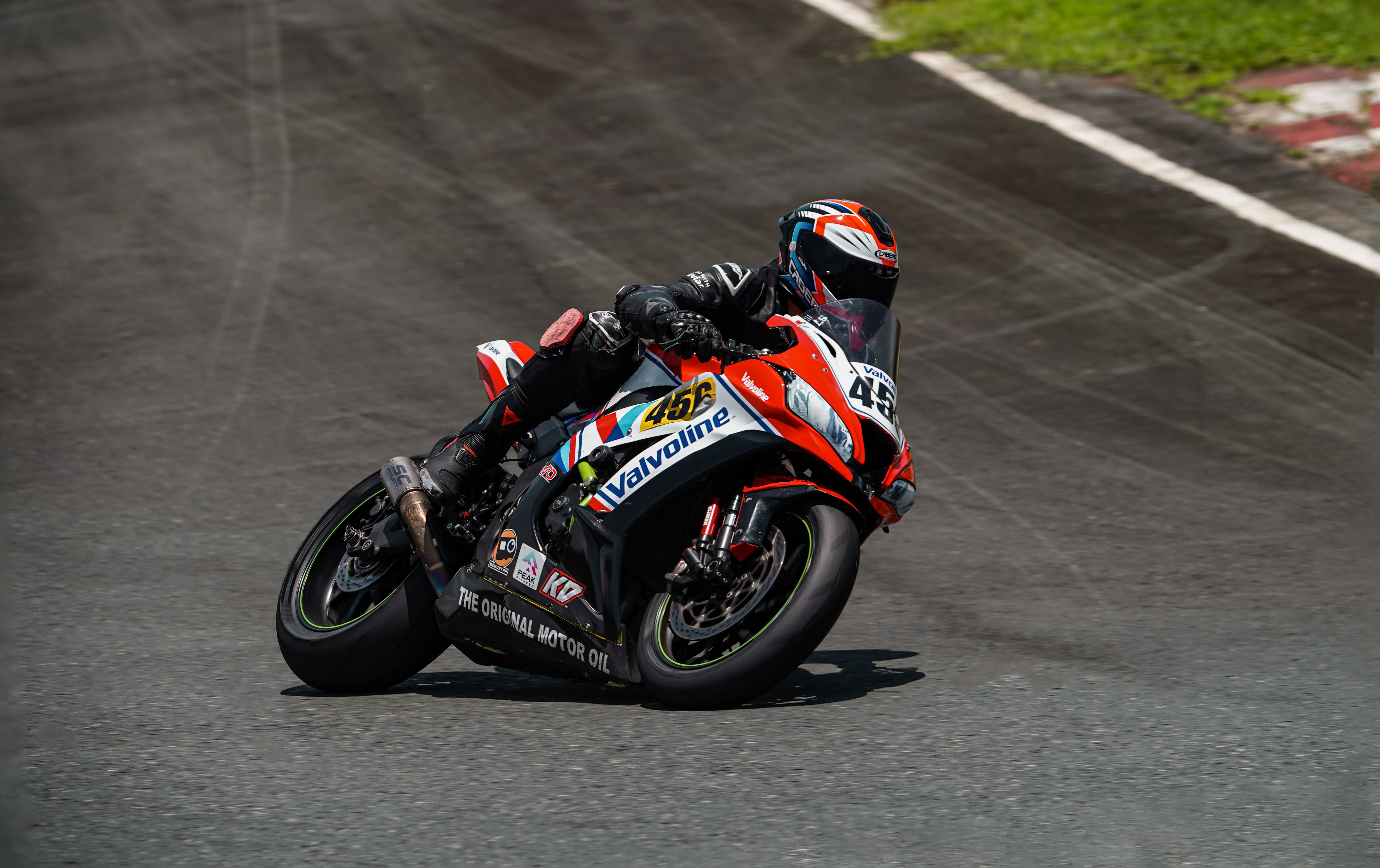 A person riding a motorcycle on a race track · Free Stock Photo