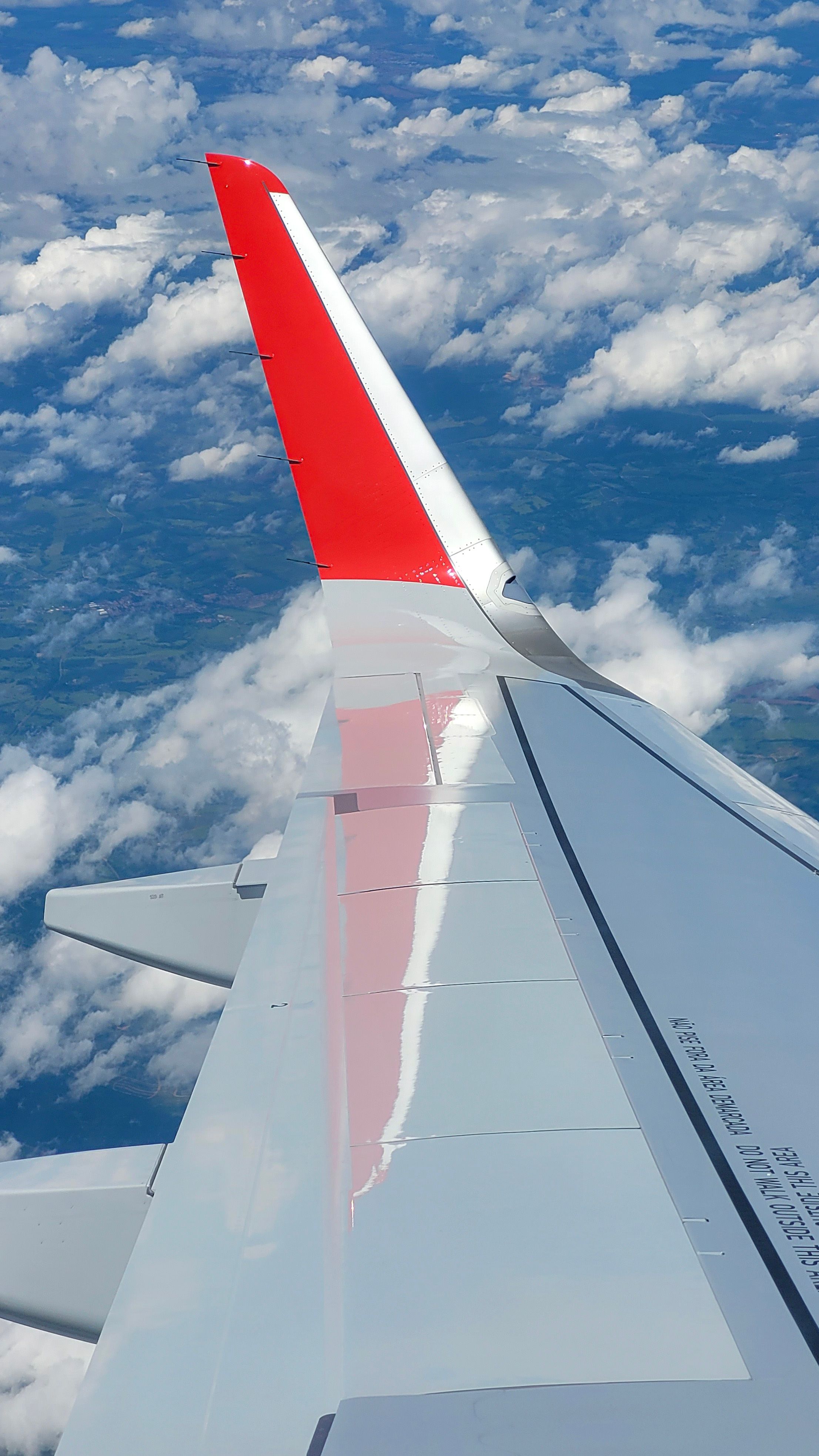 An airplane wing with a red and white stripe · Free Stock Photo