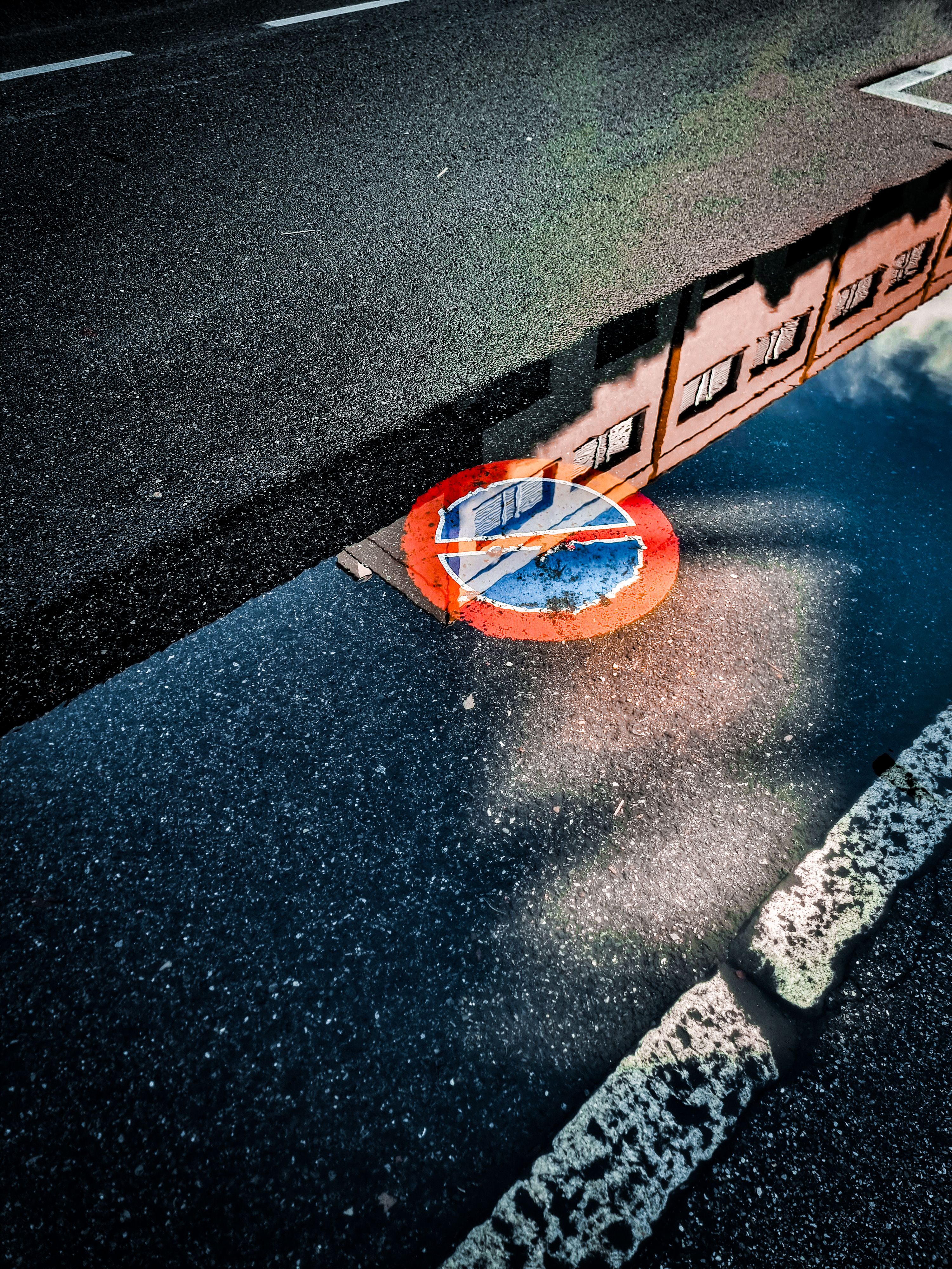 A reflection of a street sign on a puddle · Free Stock Photo