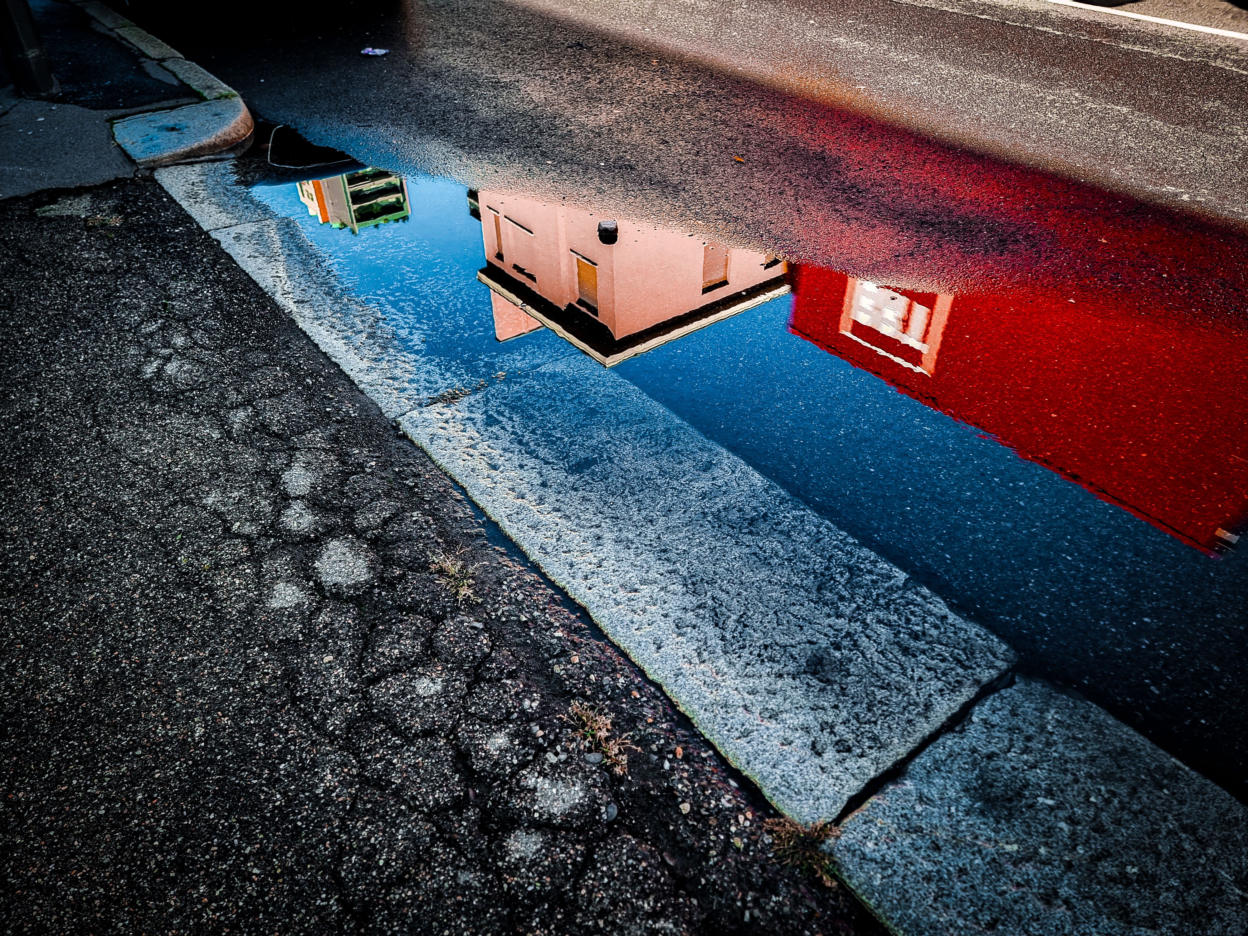 A reflection of a building in a puddle · Free Stock Photo