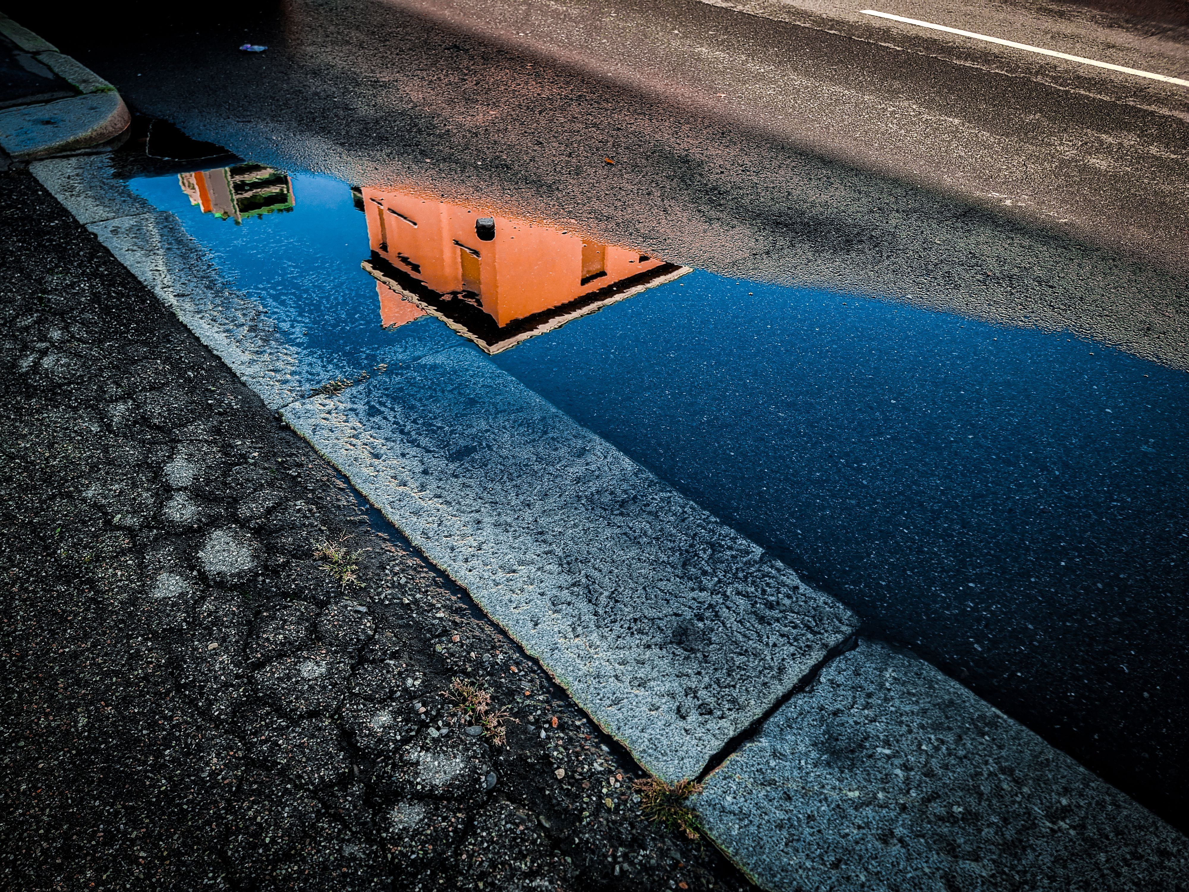 A reflection of a building in a puddle · Free Stock Photo