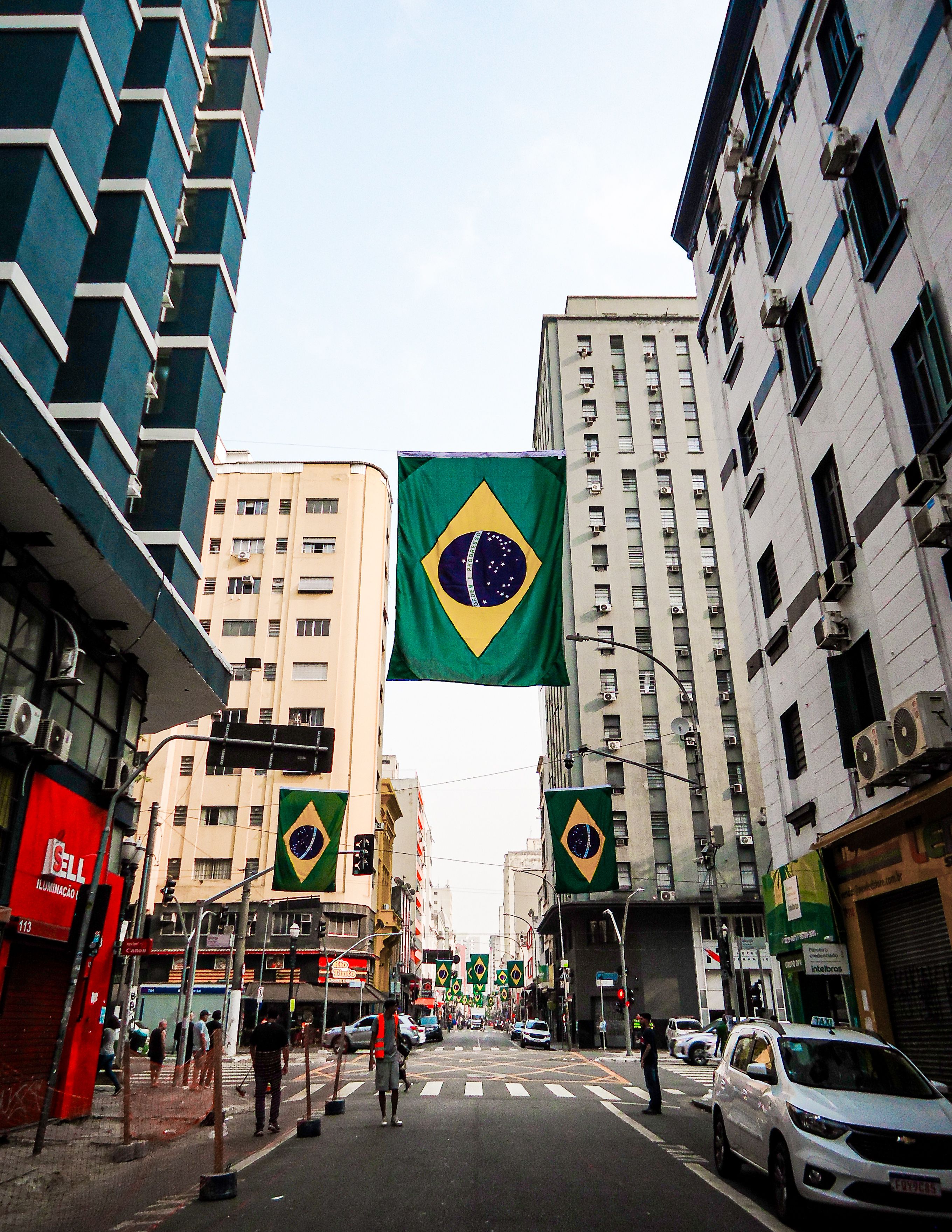 Urban Street in Brazil with Flags Displayed · Free Stock Photo